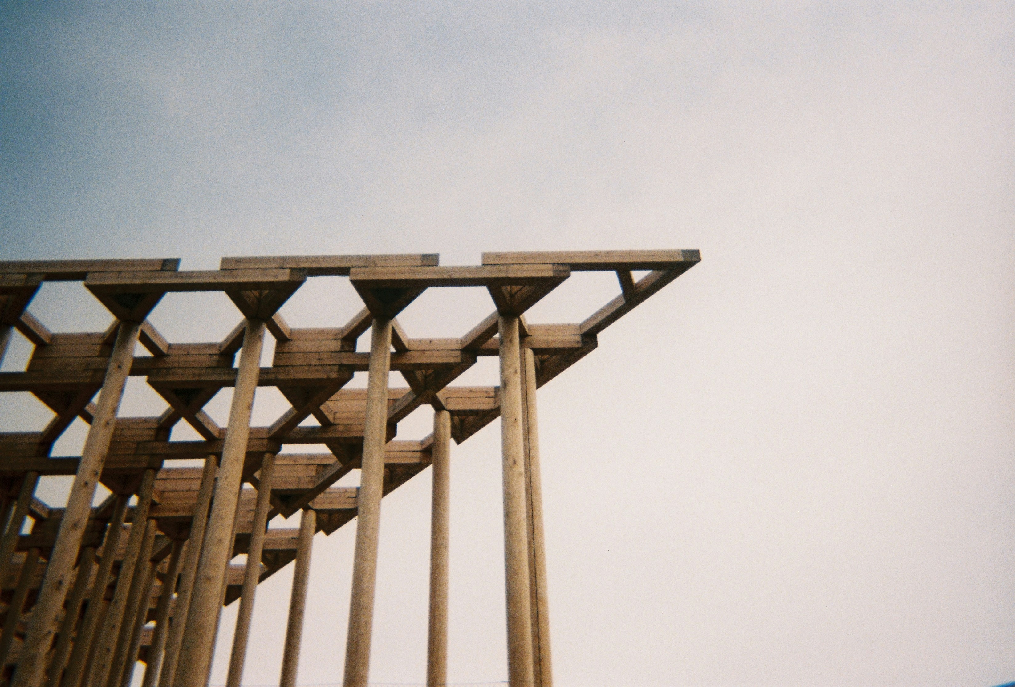 Wooden architectural structure against a cloudy sky.