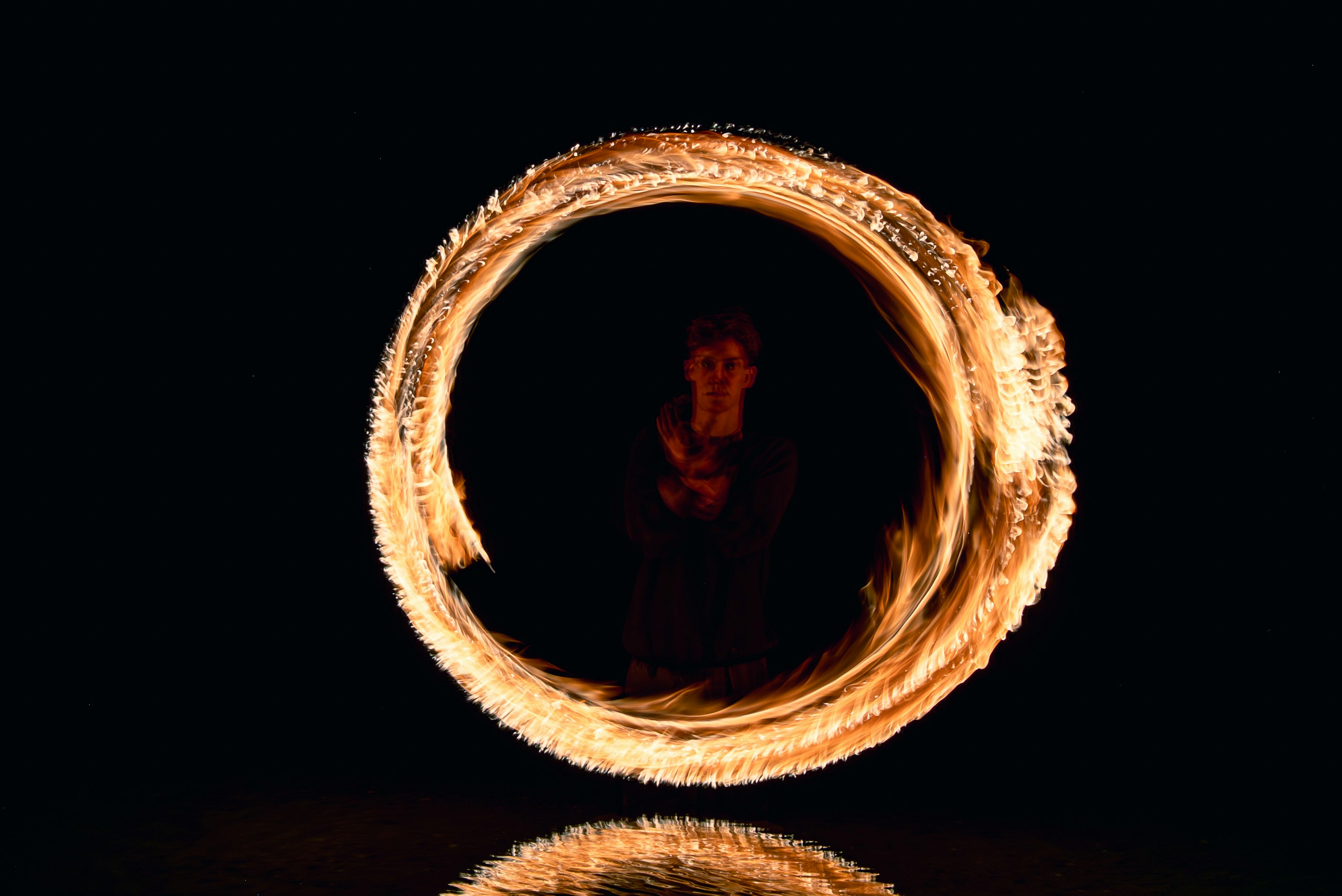 Performer creates a fiery circle against black background photo – Free ...