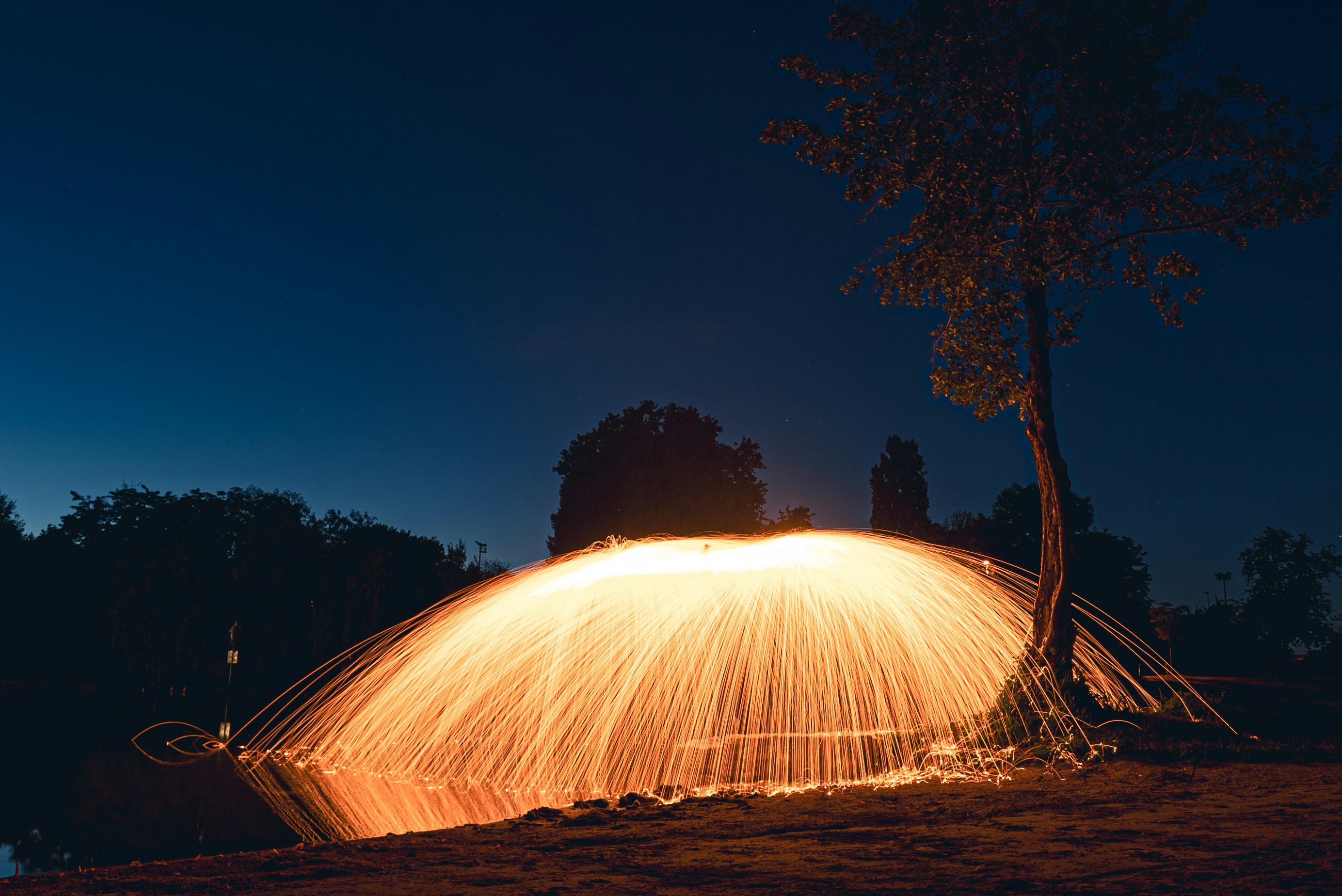 Illuminated Whirl of Sparks Above Tranquil Waters