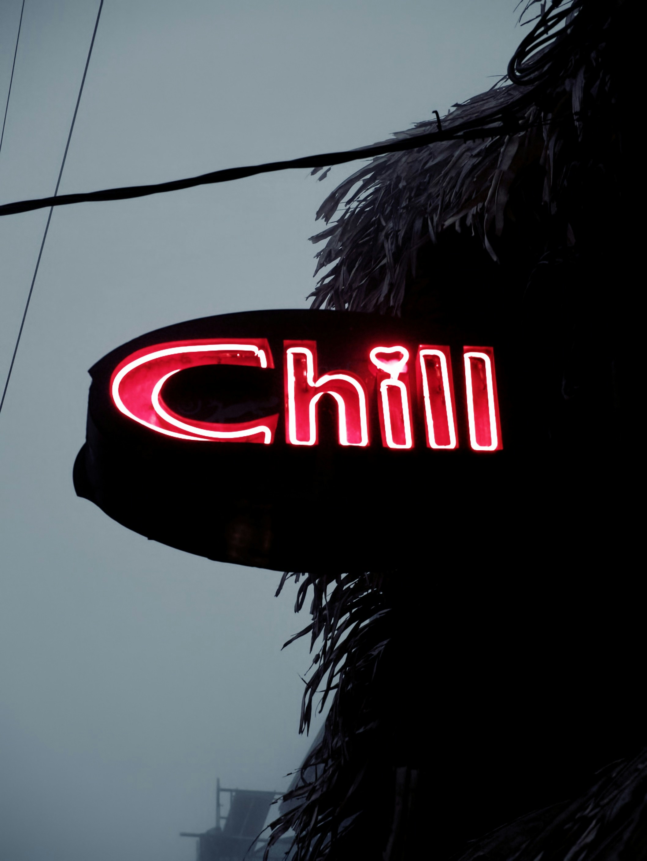 Red neon sign spelling "chill" at night