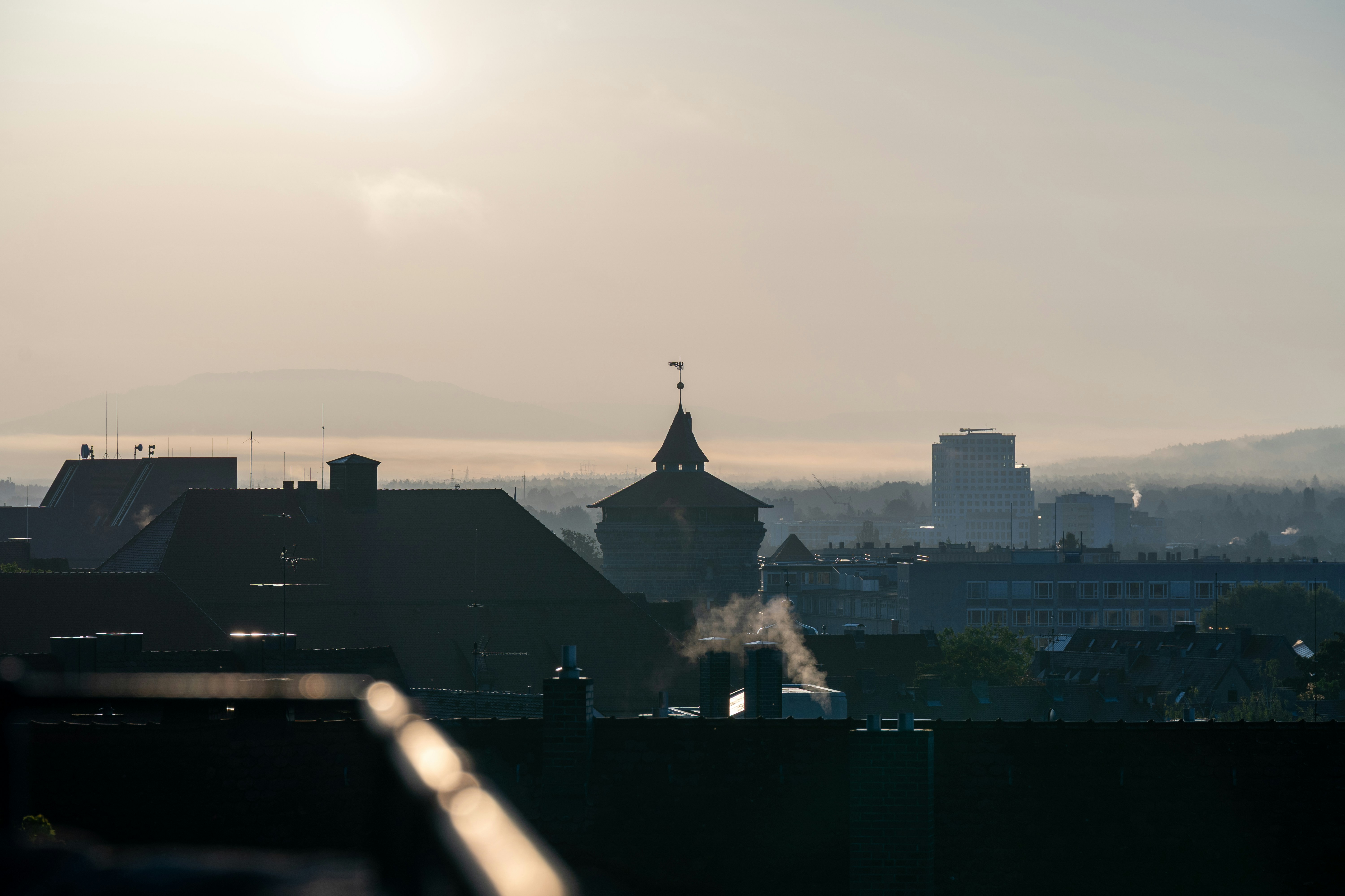 Cityscape with a church tower at sunrise.