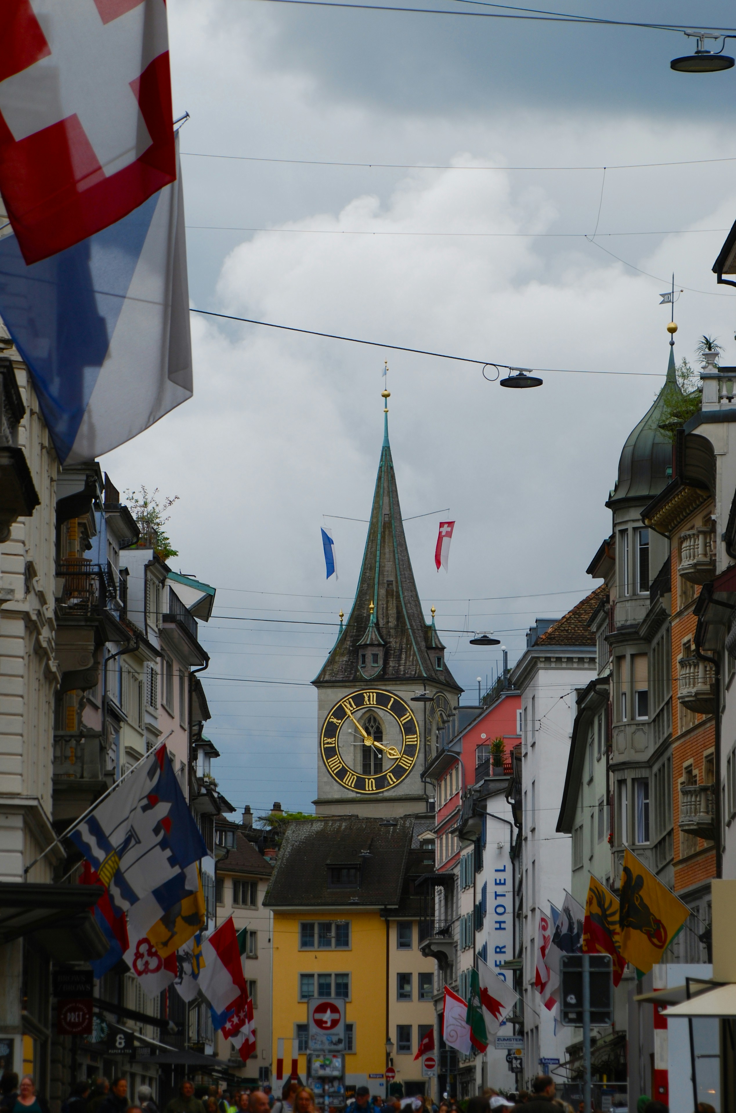 Swiss flags and clock tower in city street