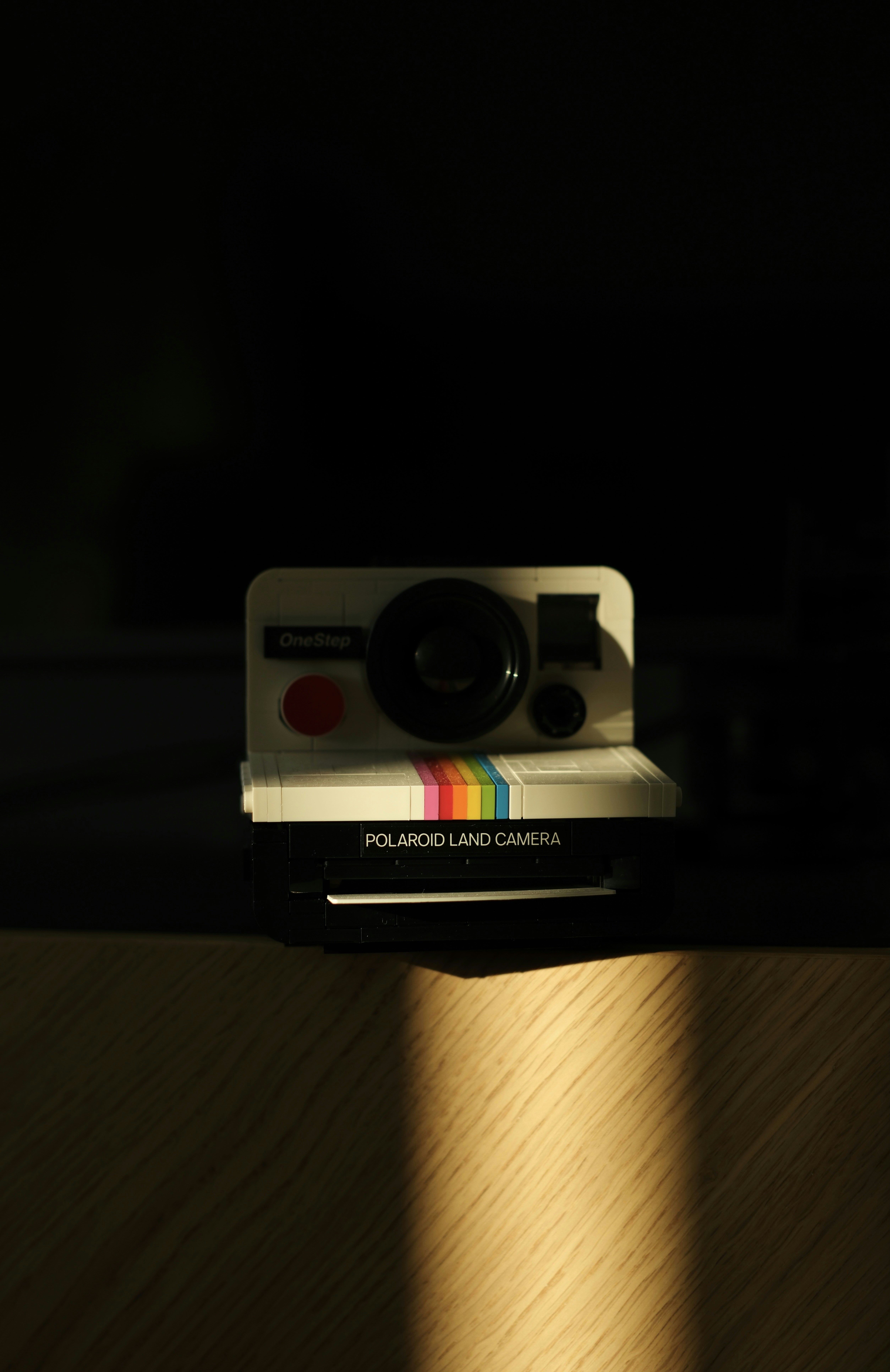 Instagram - @kaprion | A vintage polaroid land camera sits on a wooden surface.