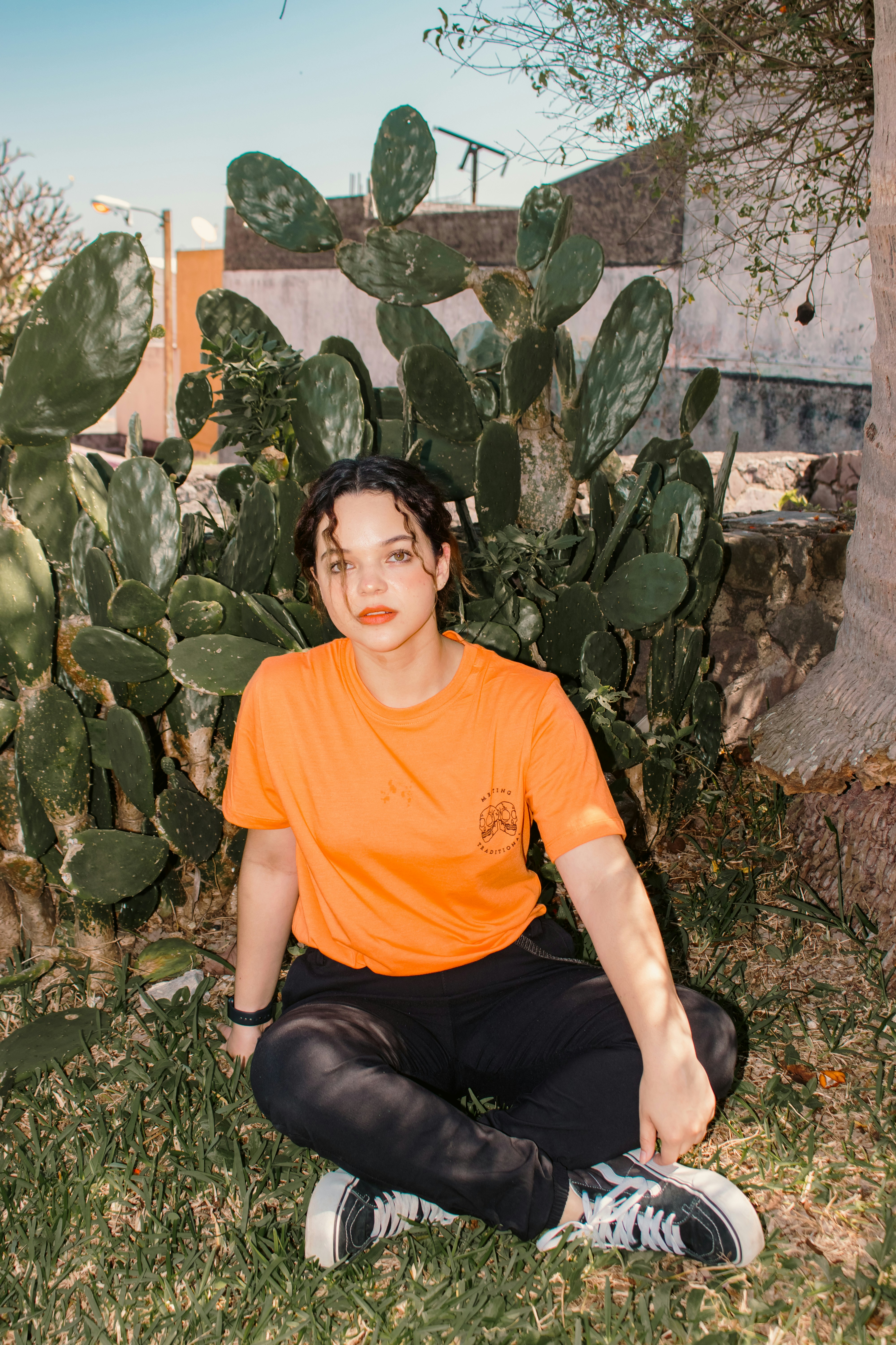 Sunlit Portrait Amid Cactus: A Quiet Moment in Orange