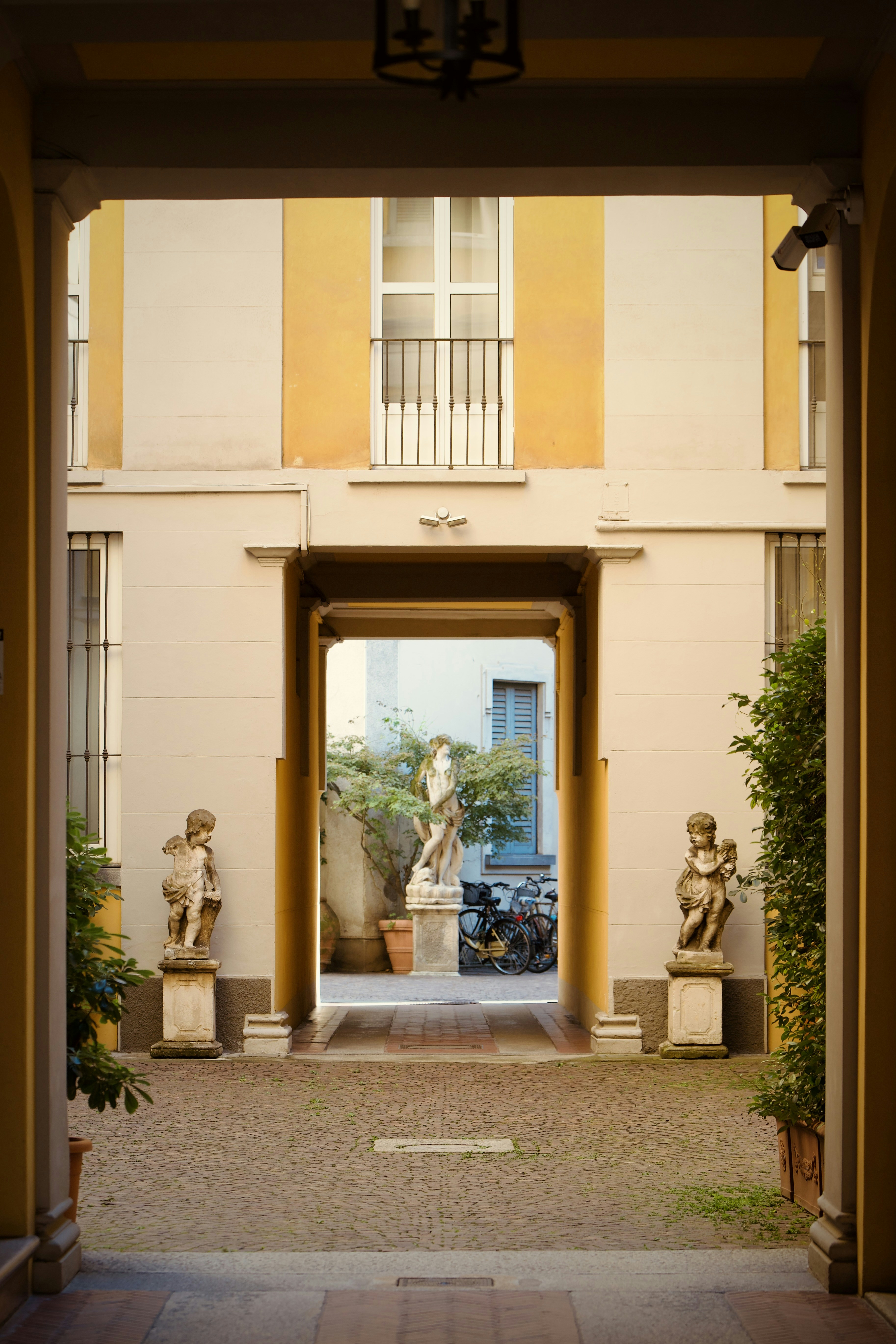 Courtyard with statues and archway leading to building photo – Free ...