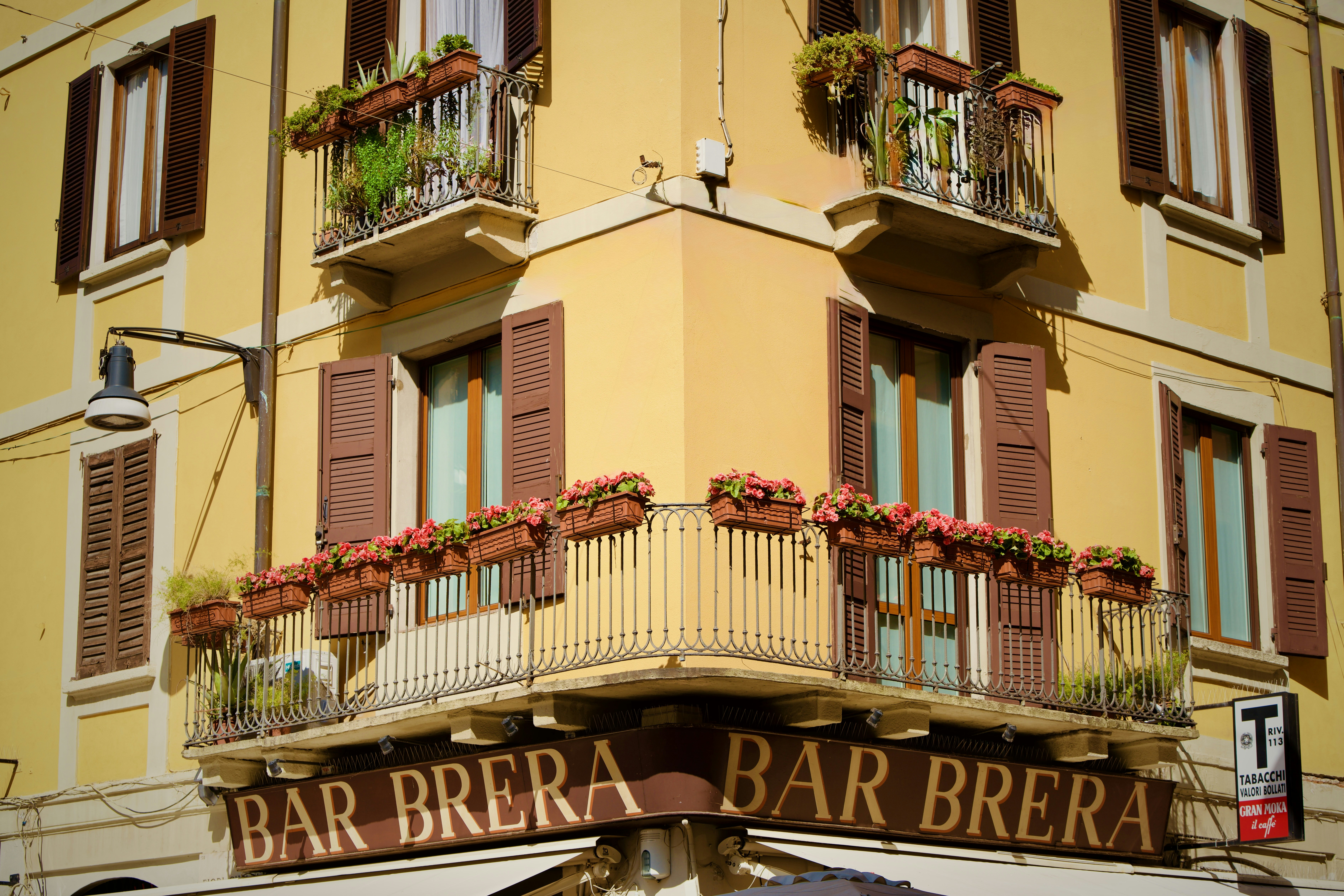 Corner of a yellow building with balconies and signs. photo – Free ...