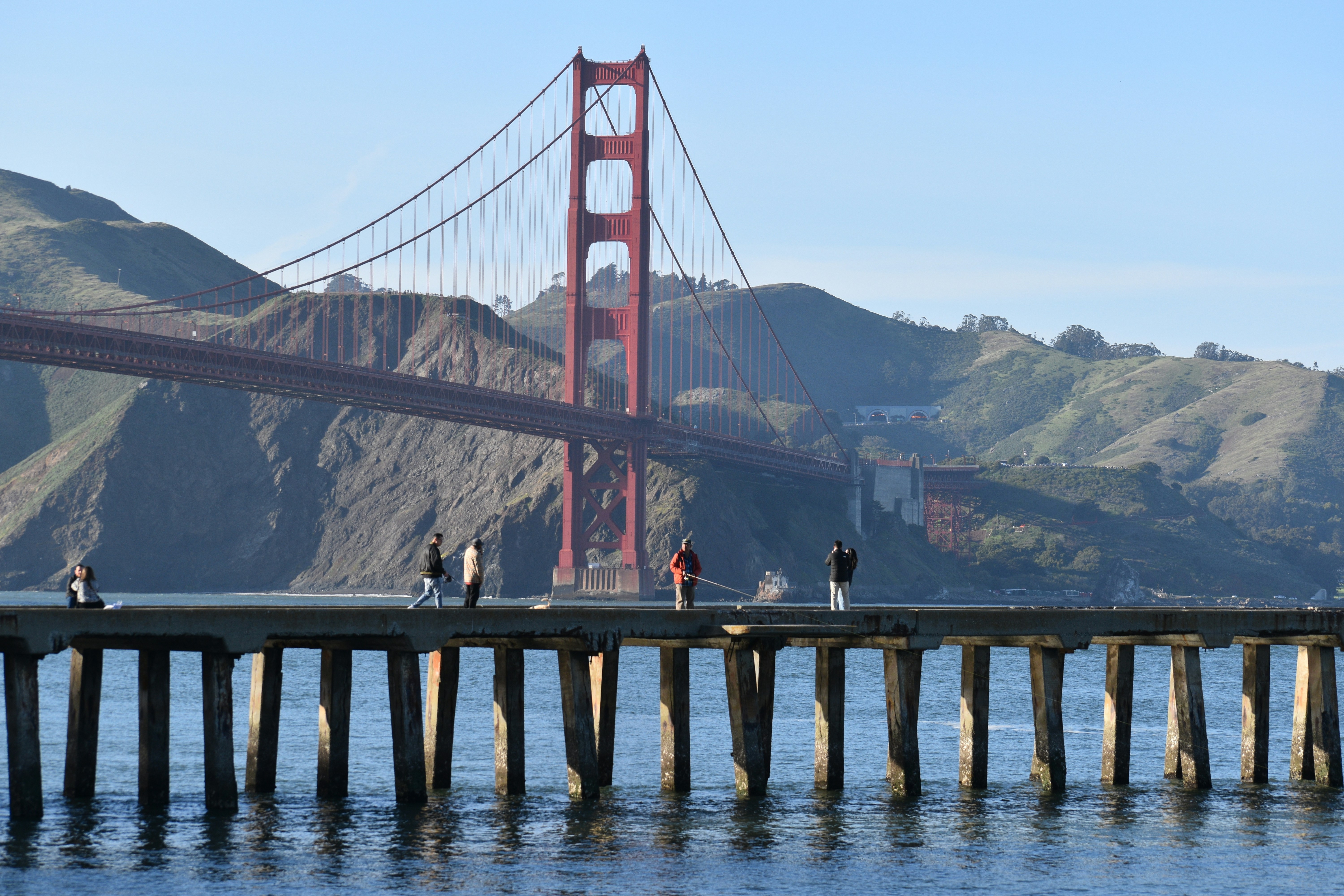 Golden gate bridge with people on a pier.