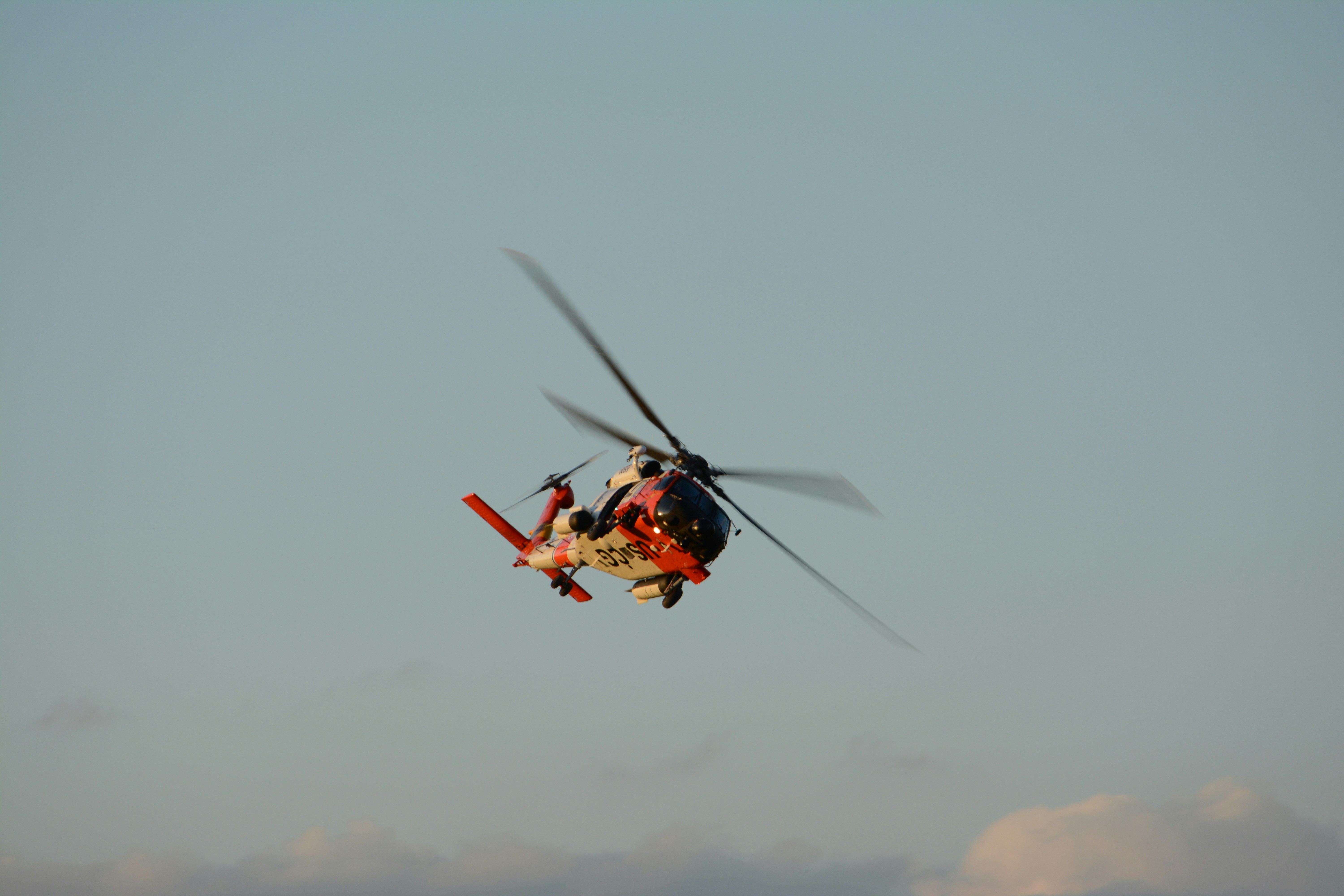 A helicopter flies in the clear blue sky.