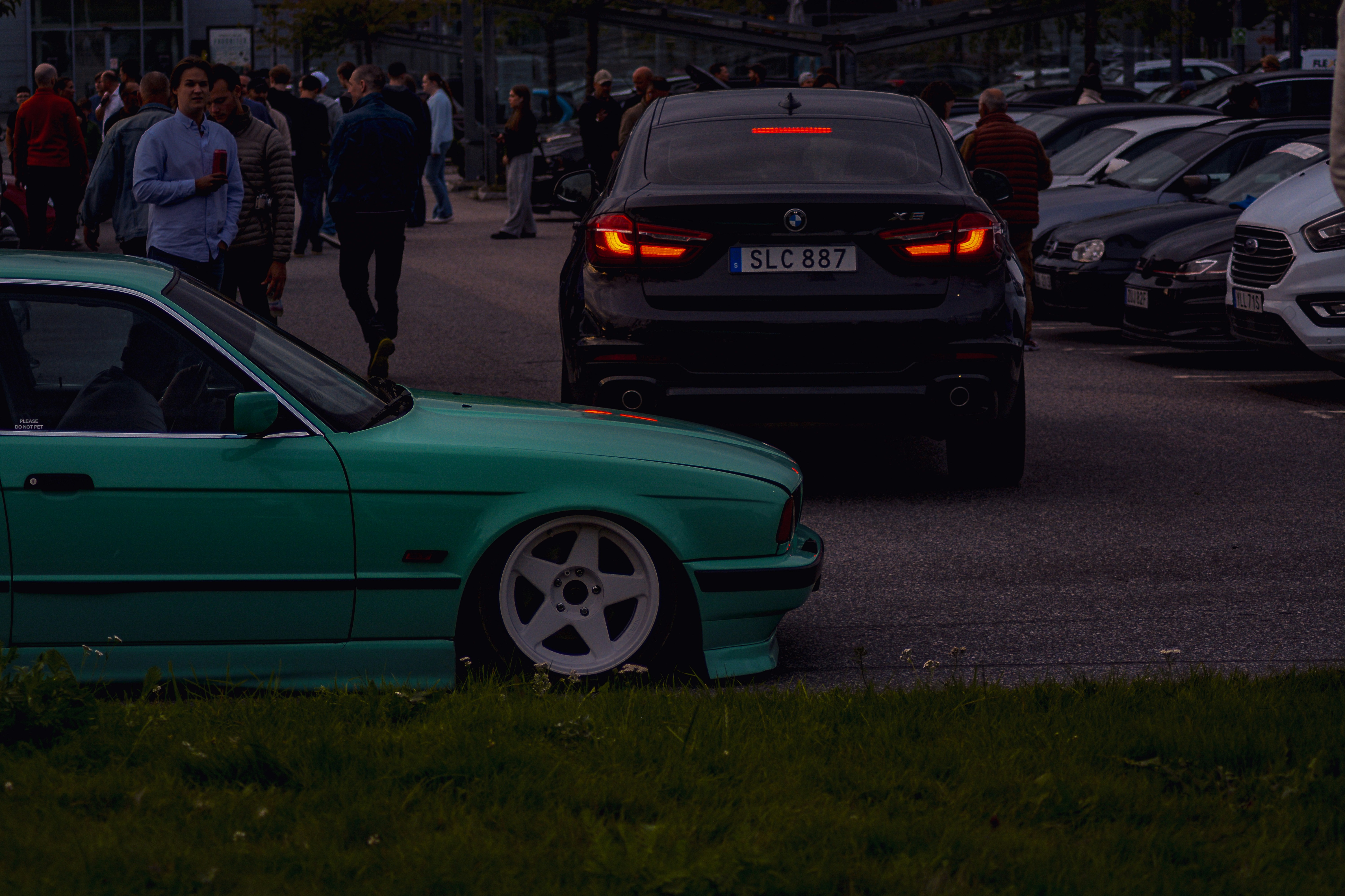 Mint green car parked next to a black suv.