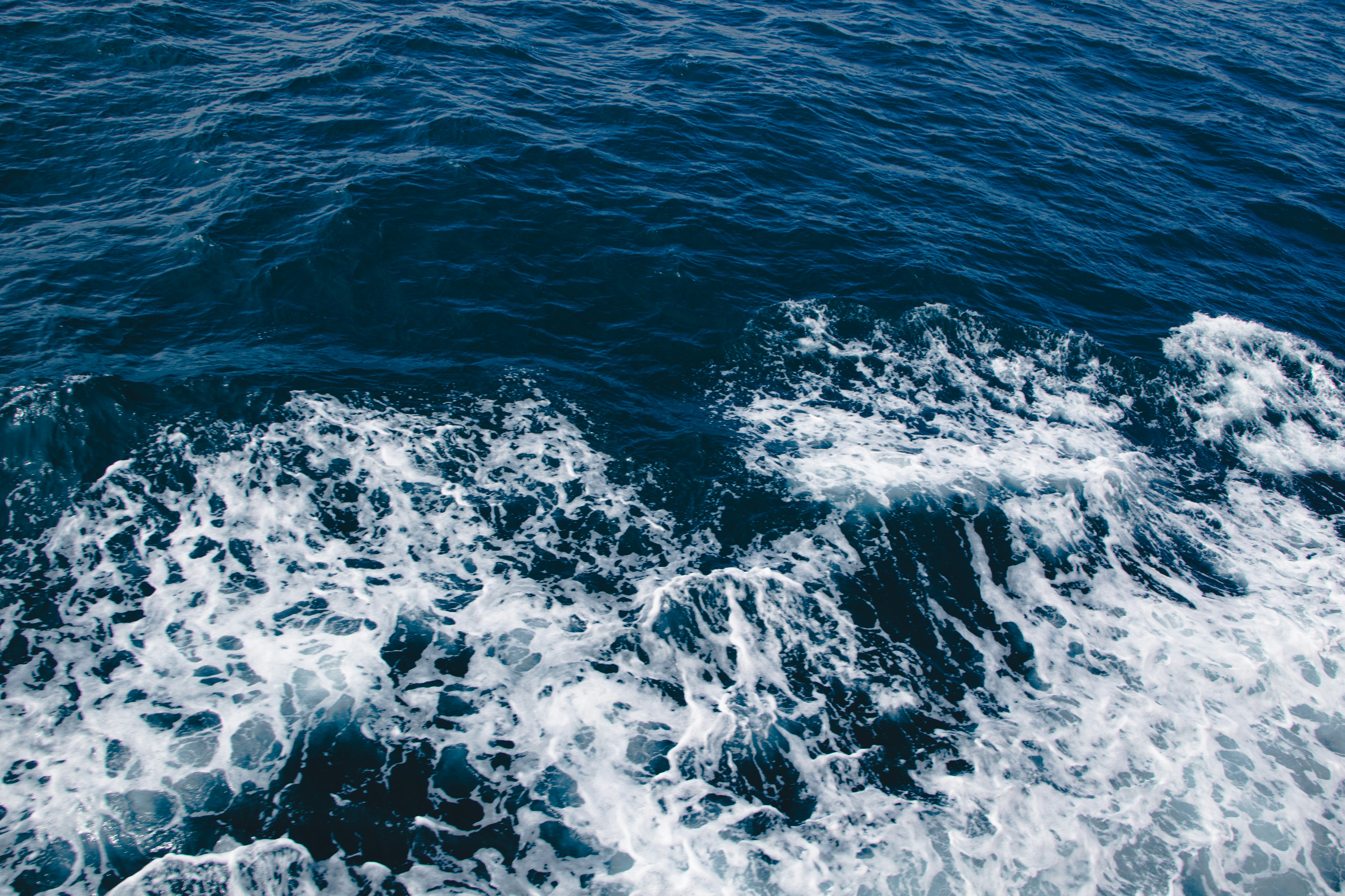 Crashing ocean waves with white foam and deep blue water.