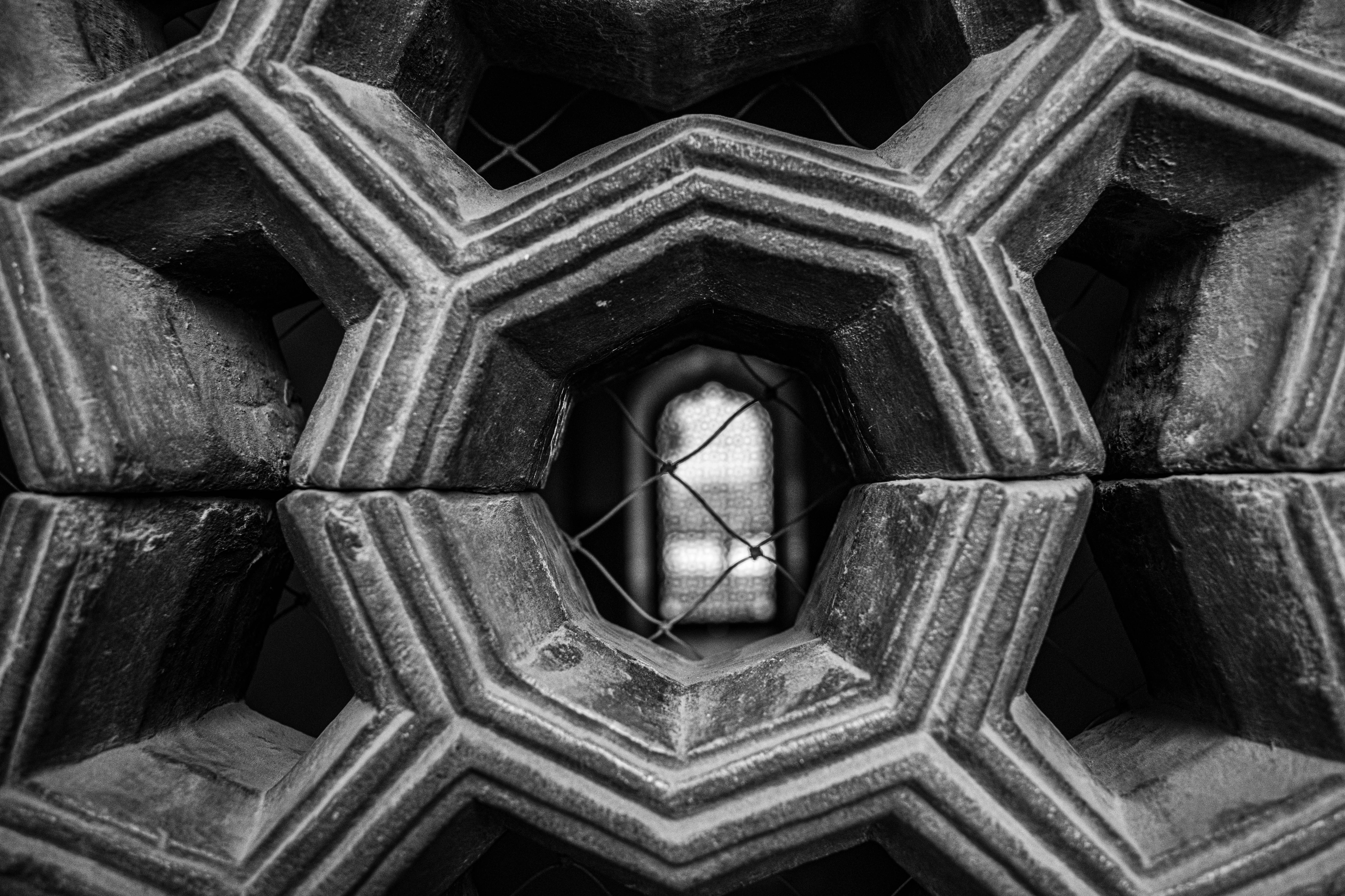 Intricate geometric stone carving with a small window