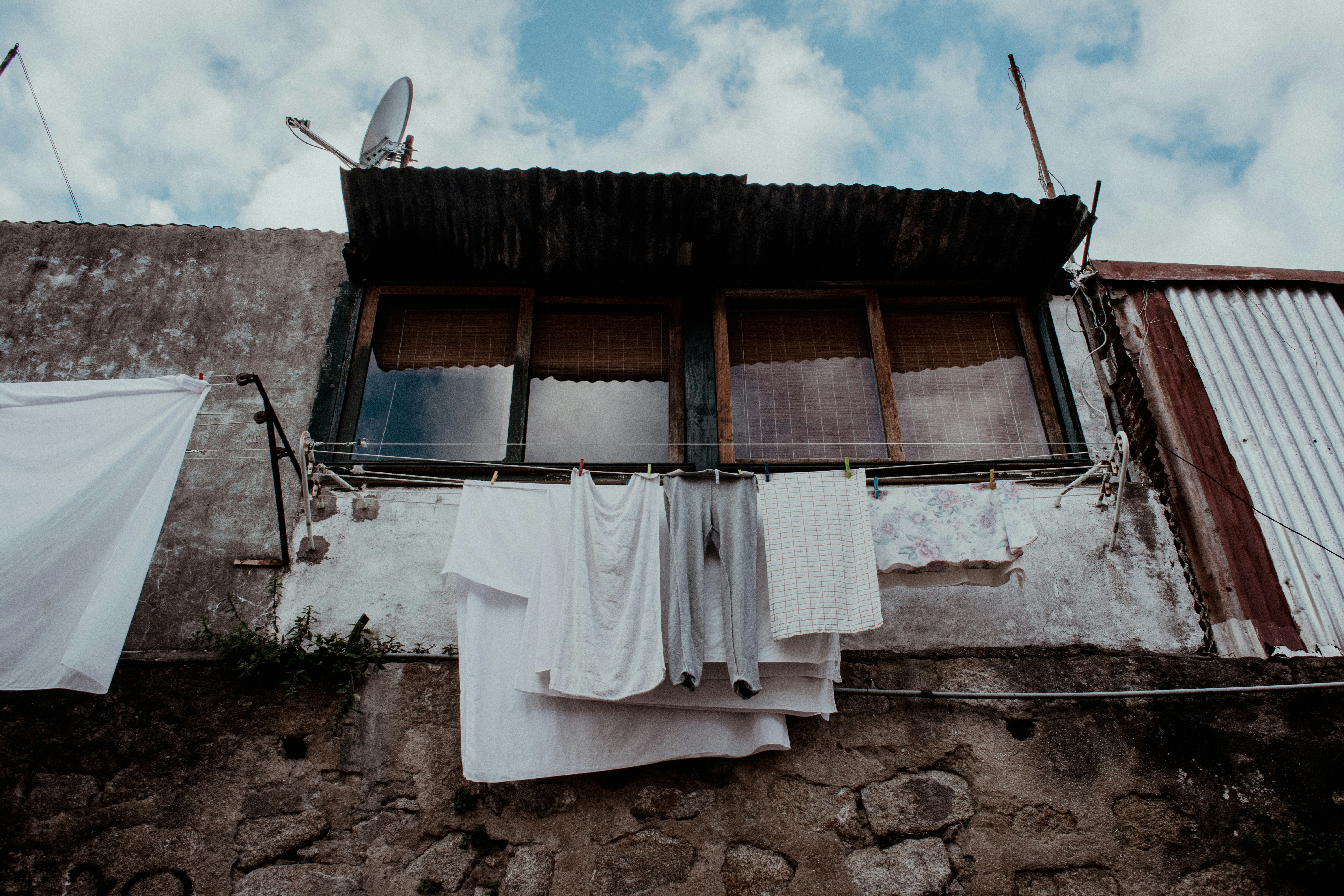 Clothes drying on a line outside a weathered building.