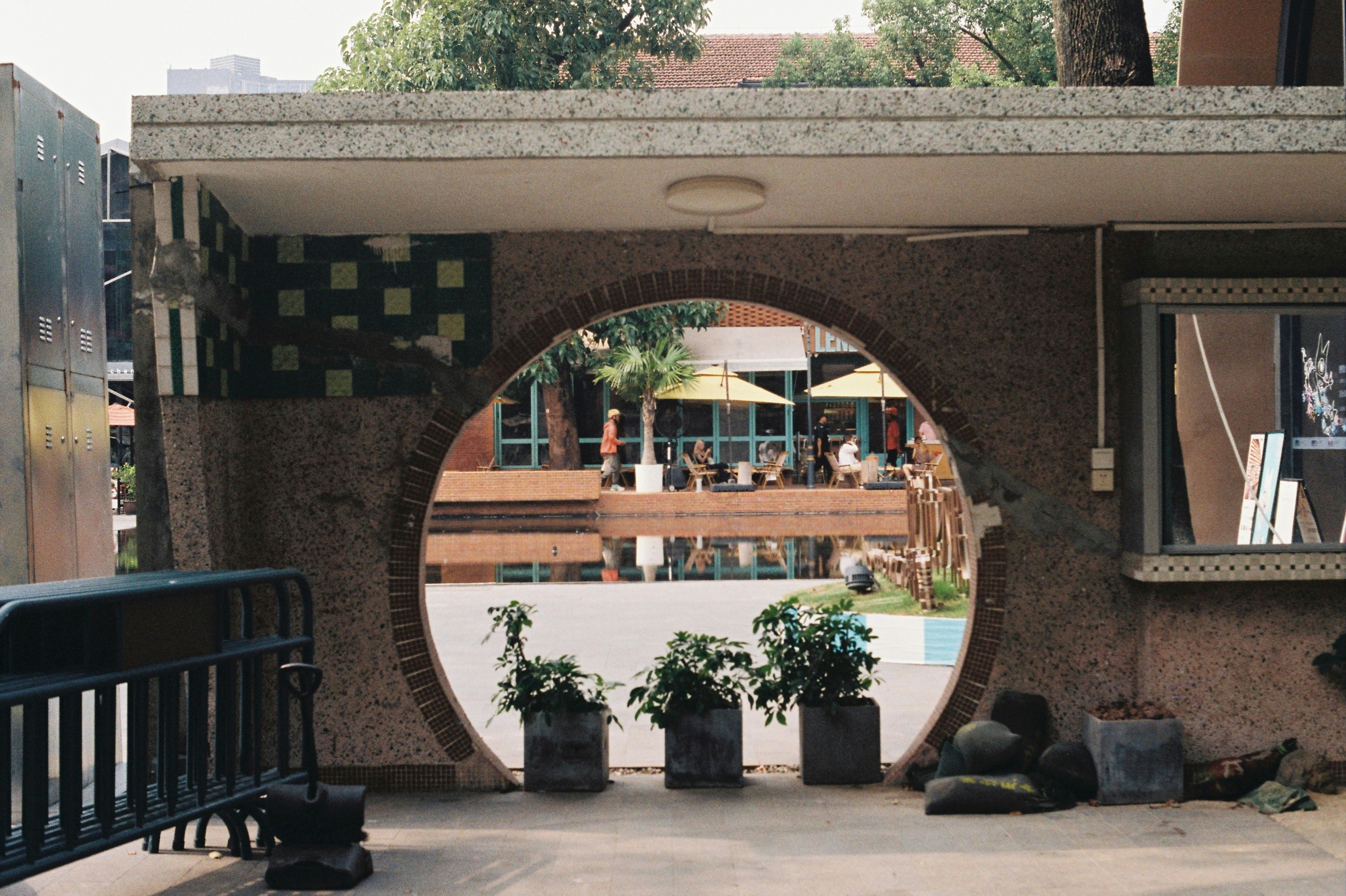 Circular opening reveals courtyard with potted plants photo – Free ...