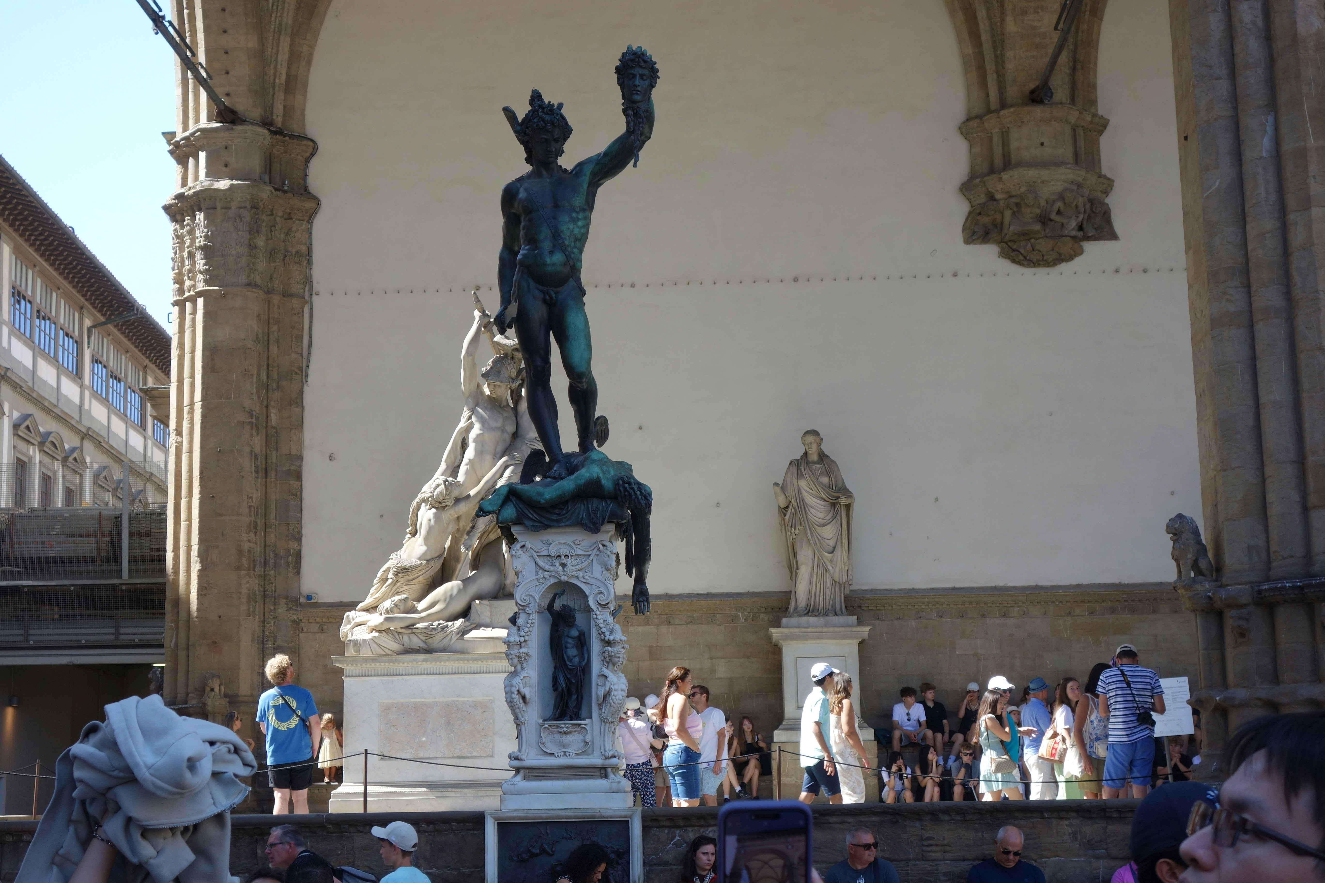 Triumphant Bronze Figure Overlooking a Bustling Piazza