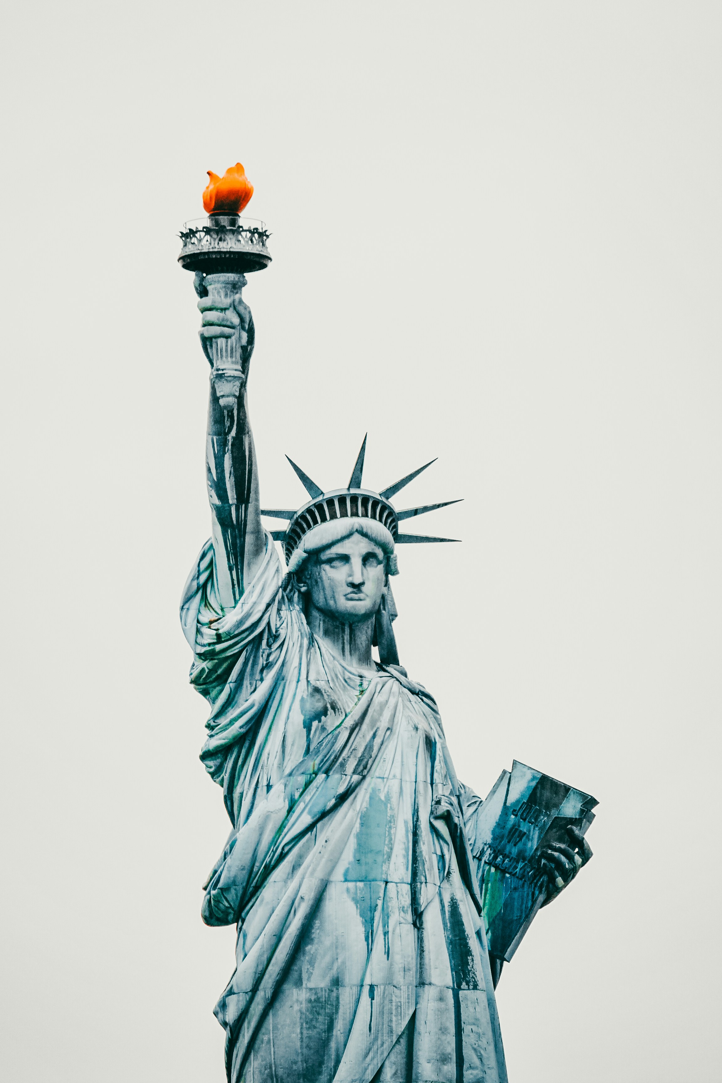 Statue of liberty with a small orange object on torch.