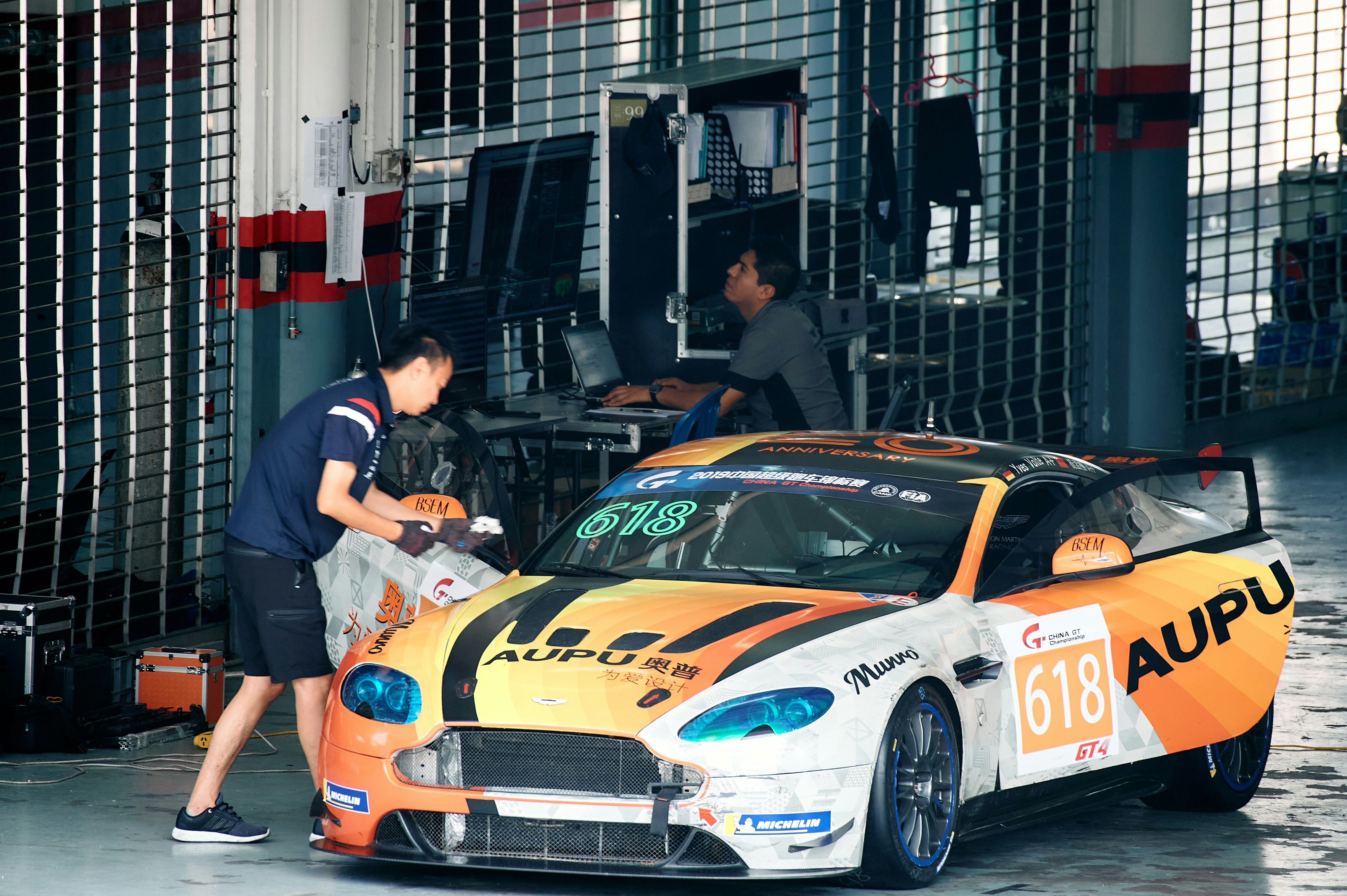 Orange race car in the pits getting last-minute prep