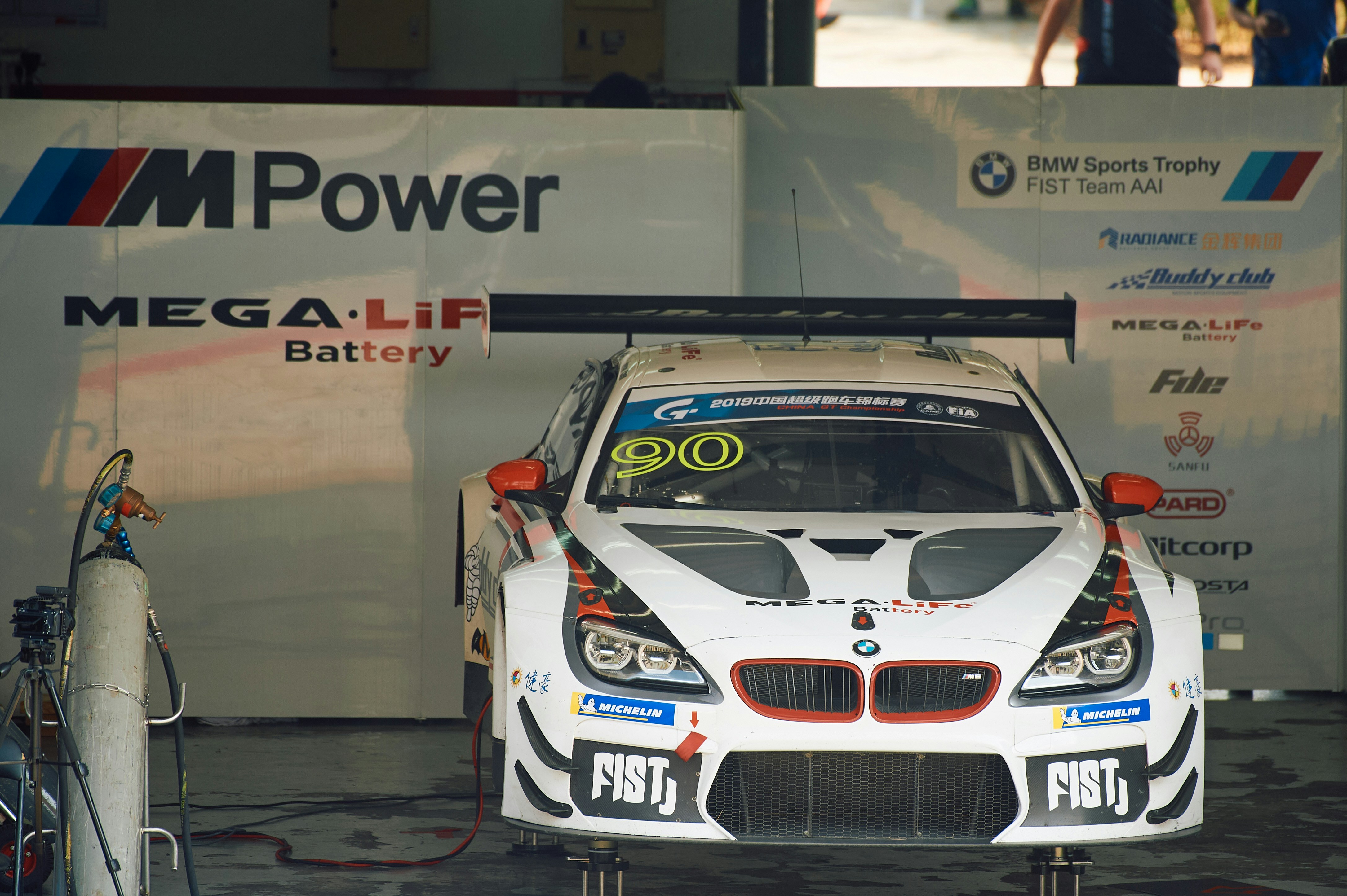 MPower BMW Racing car no 90 | White race car with sponsor decals in garage