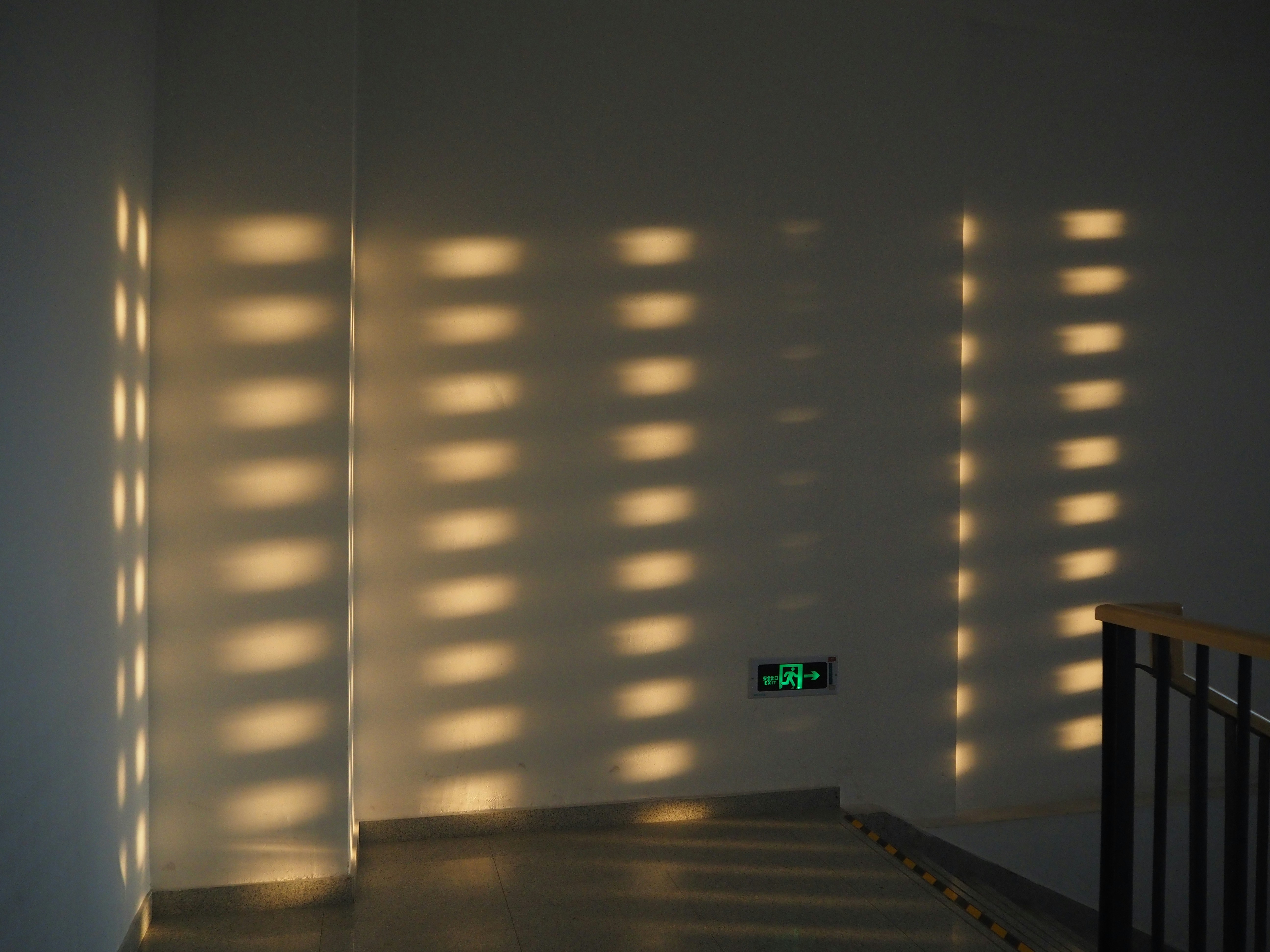 Sunlight patterns on a wall by stairs