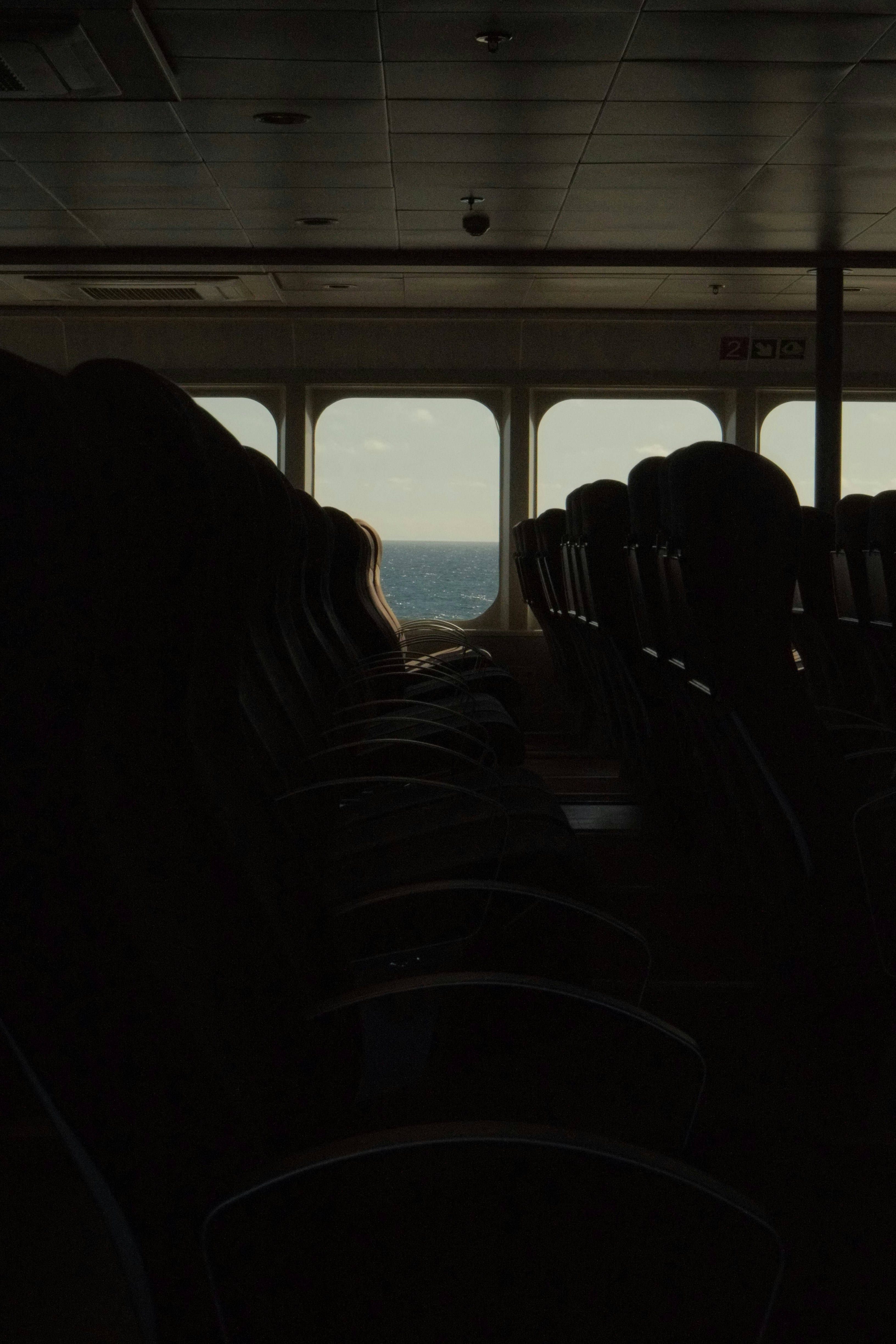 Empty seats on a ferry looking out at the ocean.