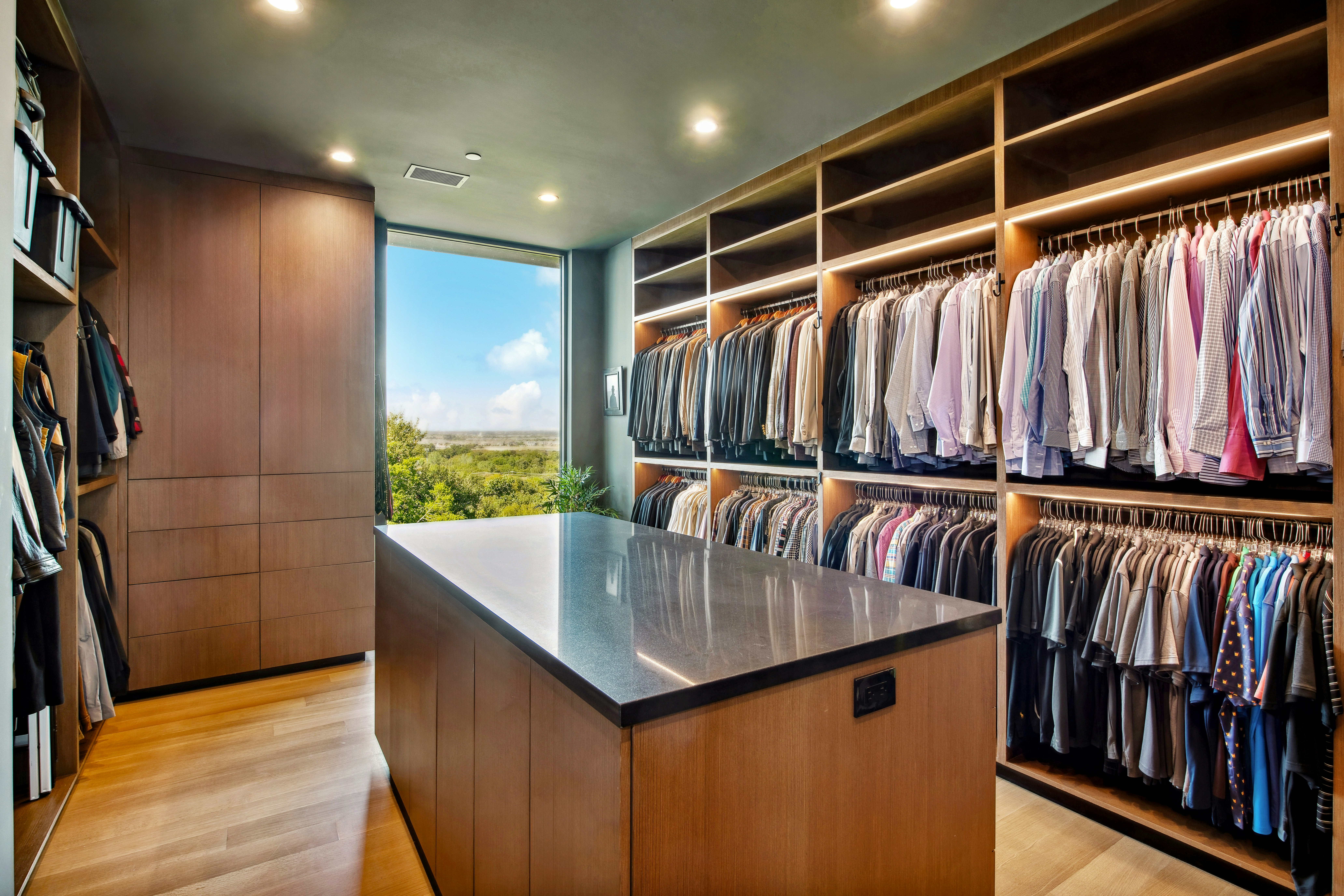 Luxurious walk-in closet with island and abundant clothing storage.