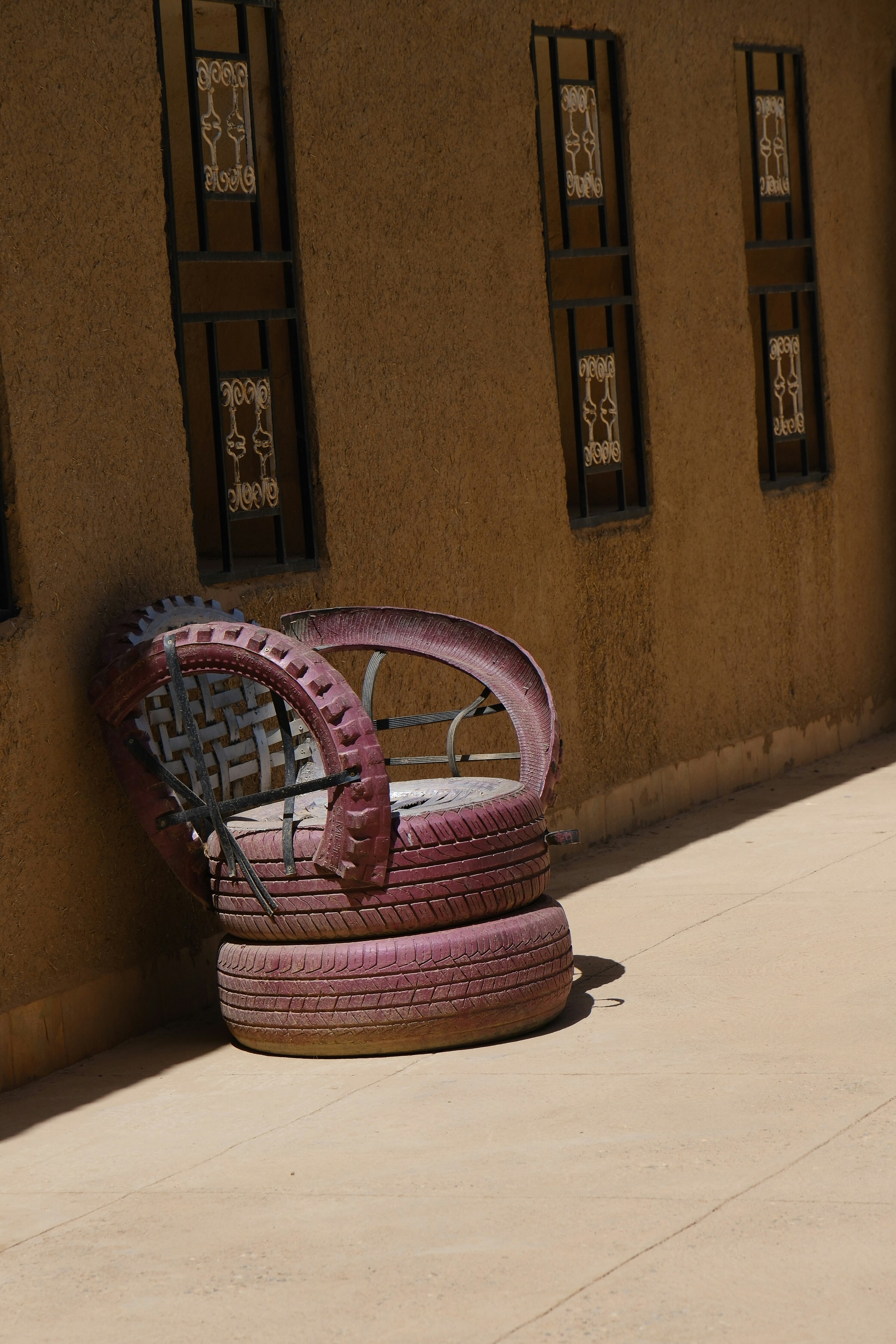Chair made from stacked tires against a wall.