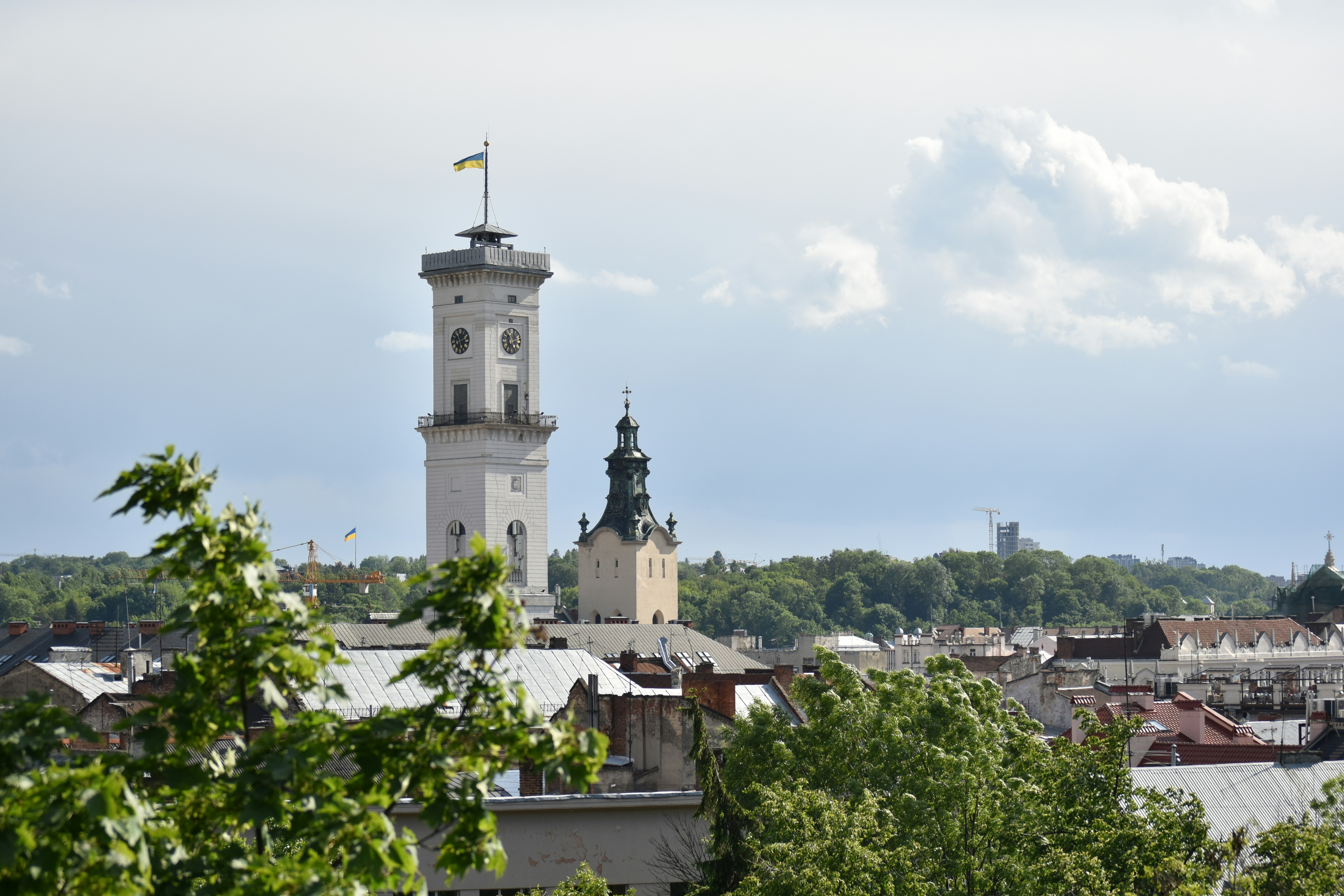 City skyline with a tall white tower and trees.