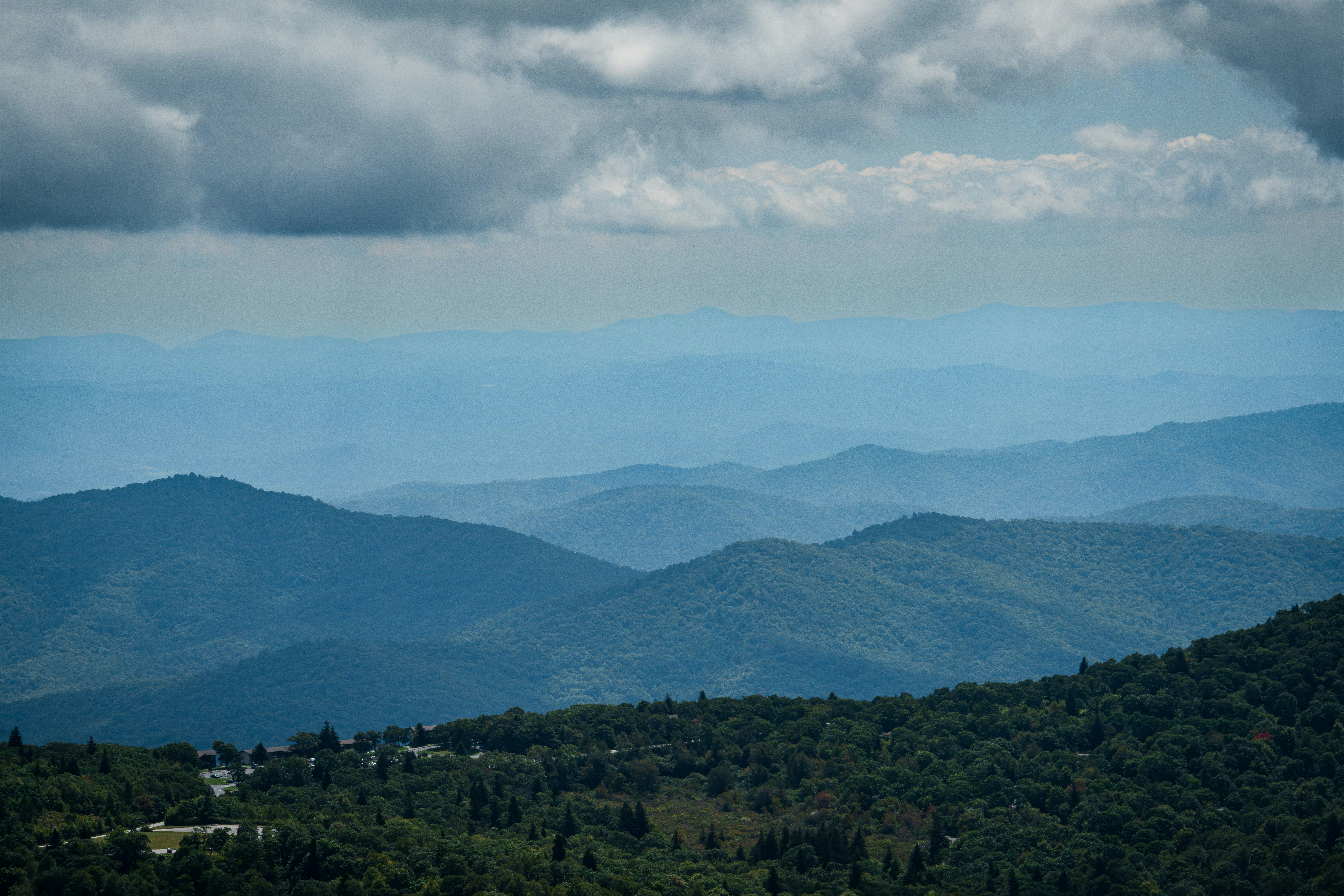 Scenic view of Appalachian mountains with atmospheric blue haze and rolling forested hills | Rolling blue mountains under a cloudy sky