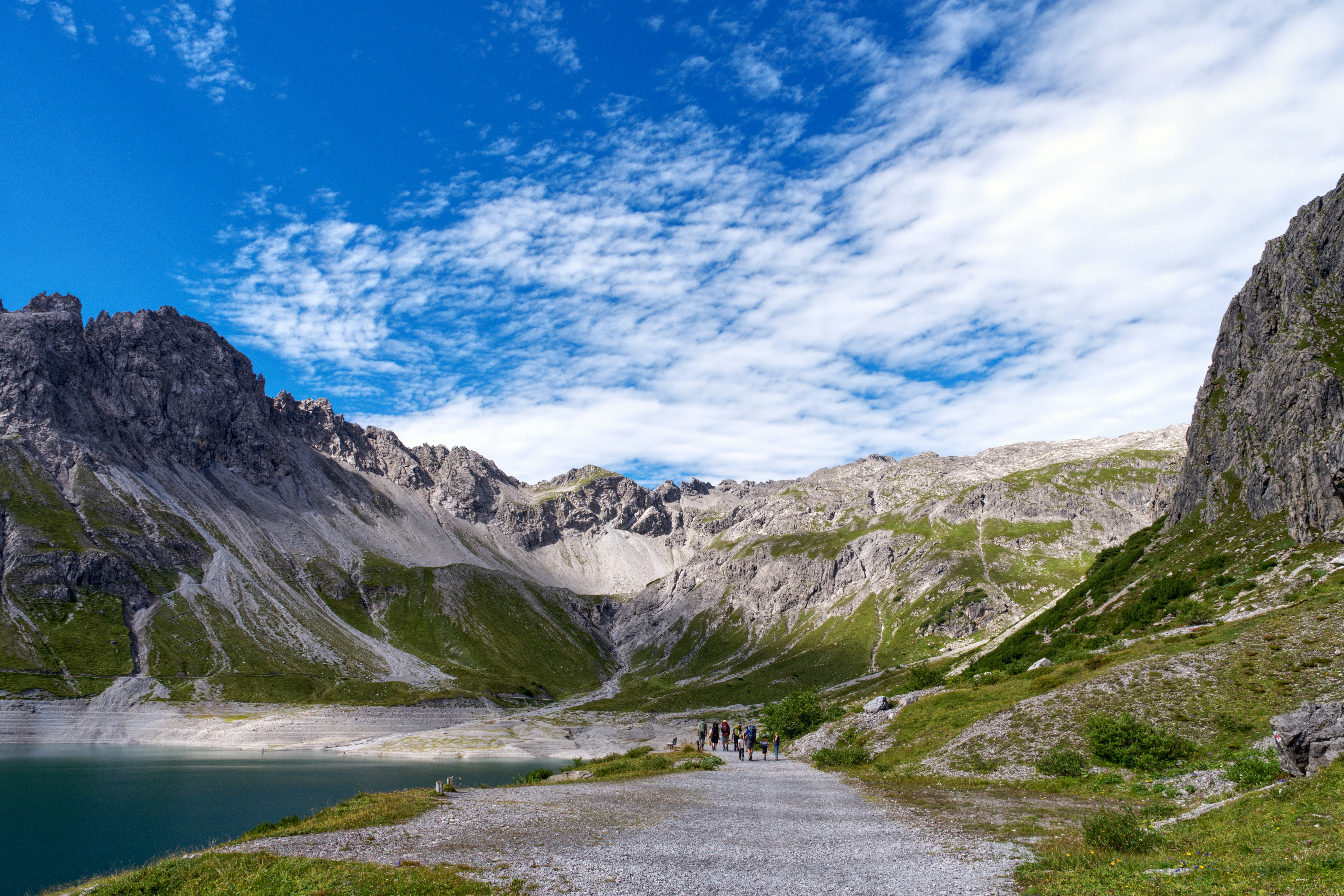 Loop road around lake Lünersee | Mountain landscape with a lake under a blue sky.
