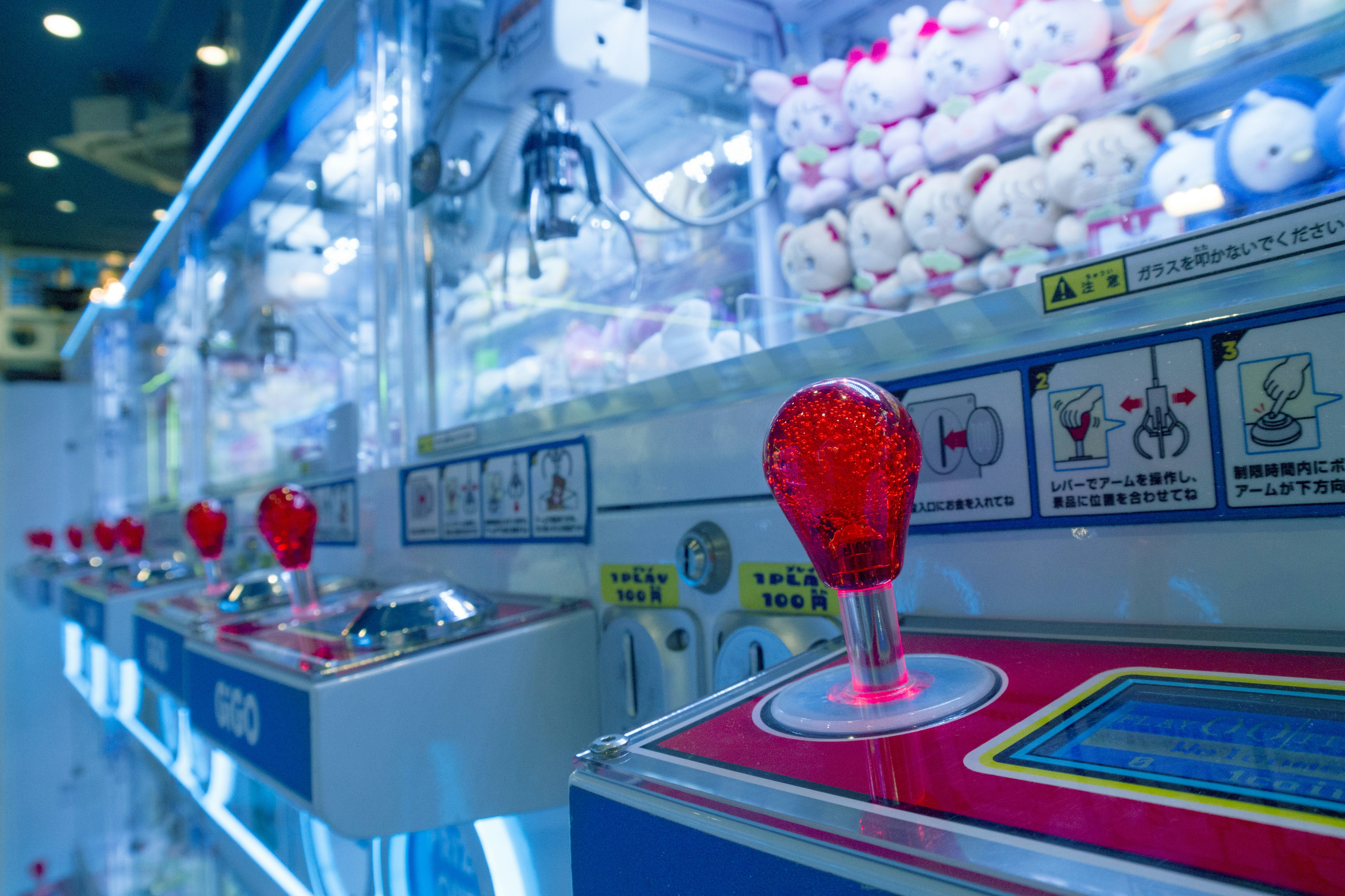 Rows of claw machines in Akihabara, Tokyo | Row of colorful arcade claw machines with prizes
