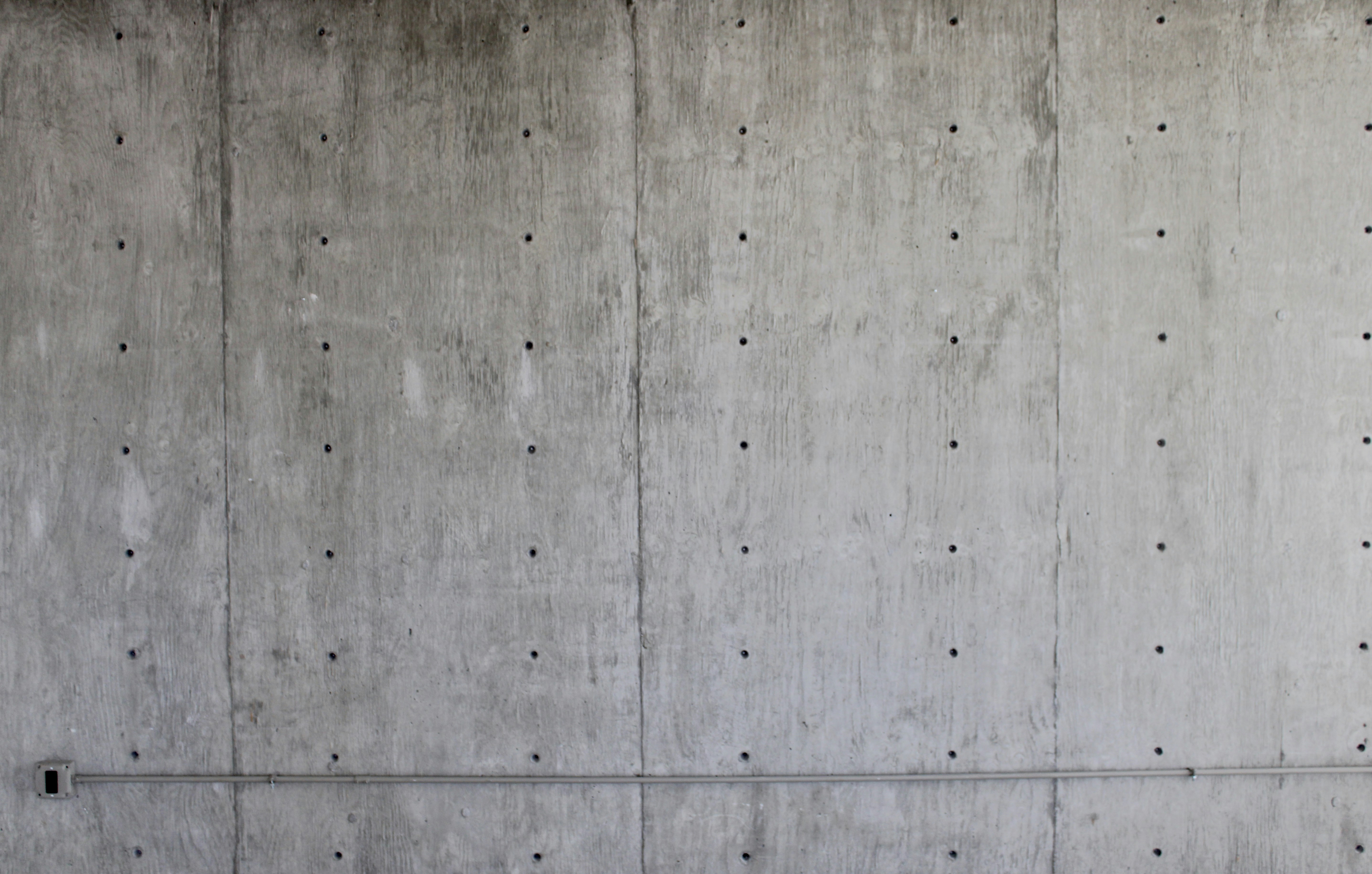 A textured concrete wall with horizontal line.