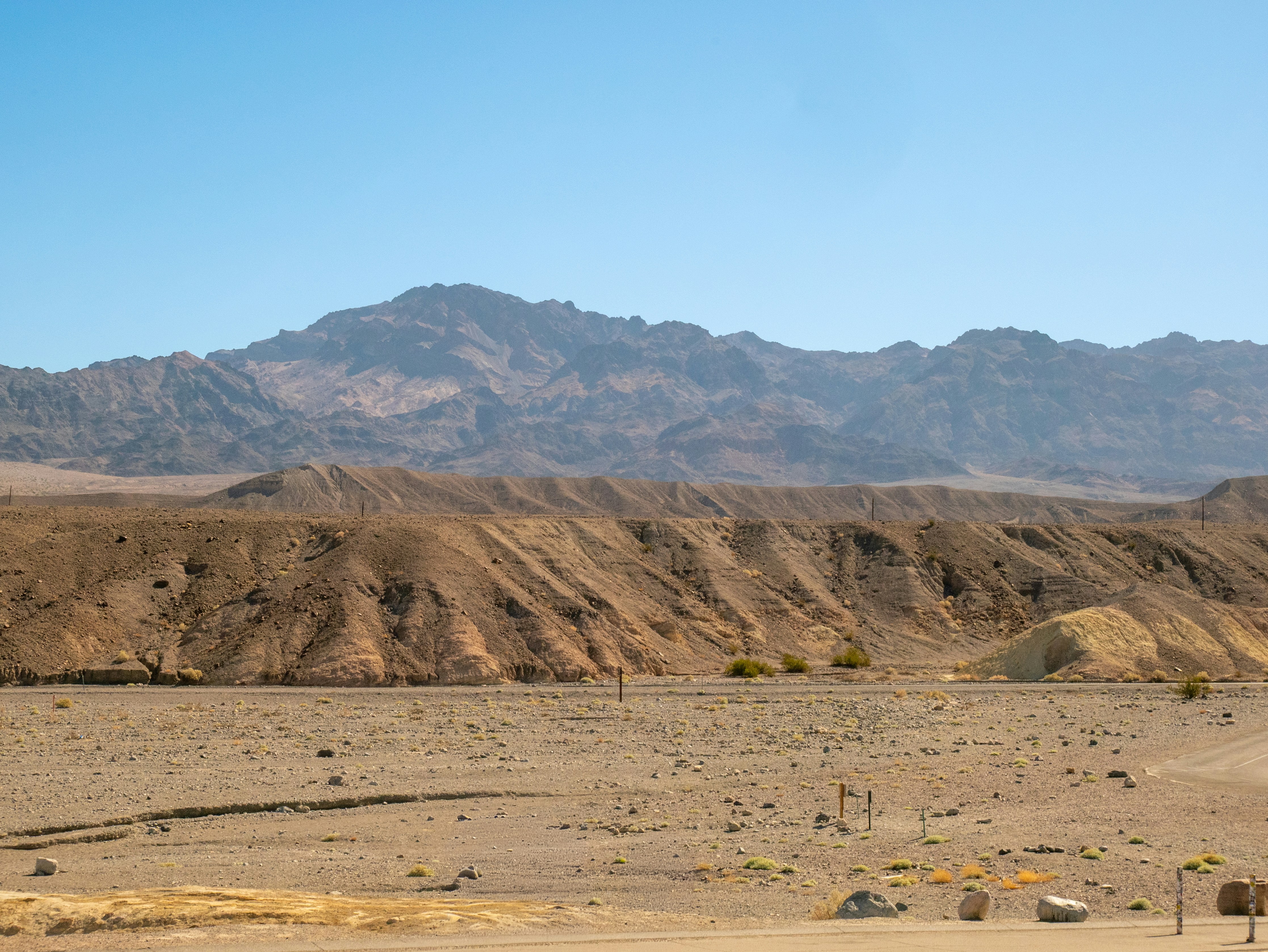Arid desert landscape with rolling hills and mountains.