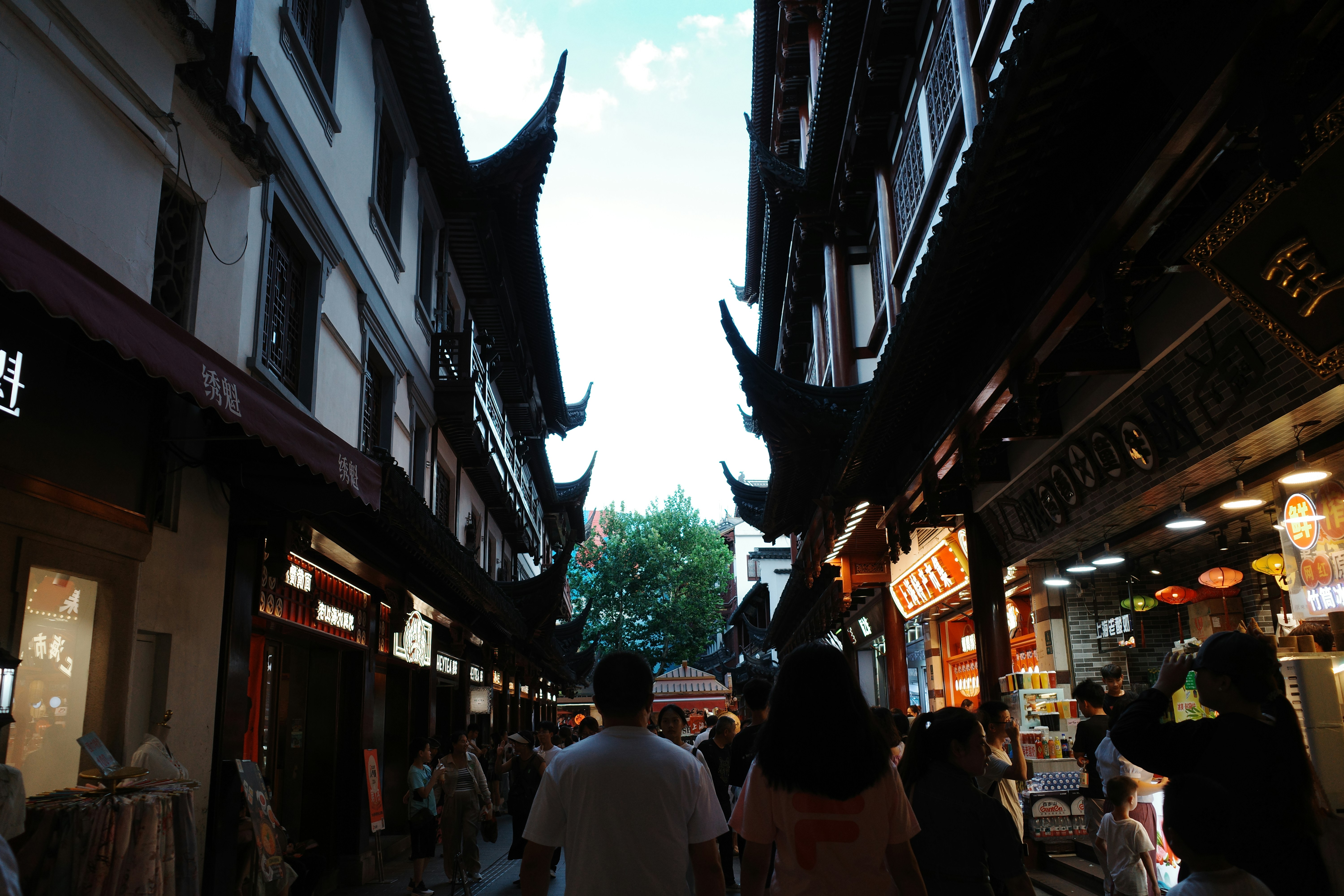 People walking down a narrow street with traditional buildings.
