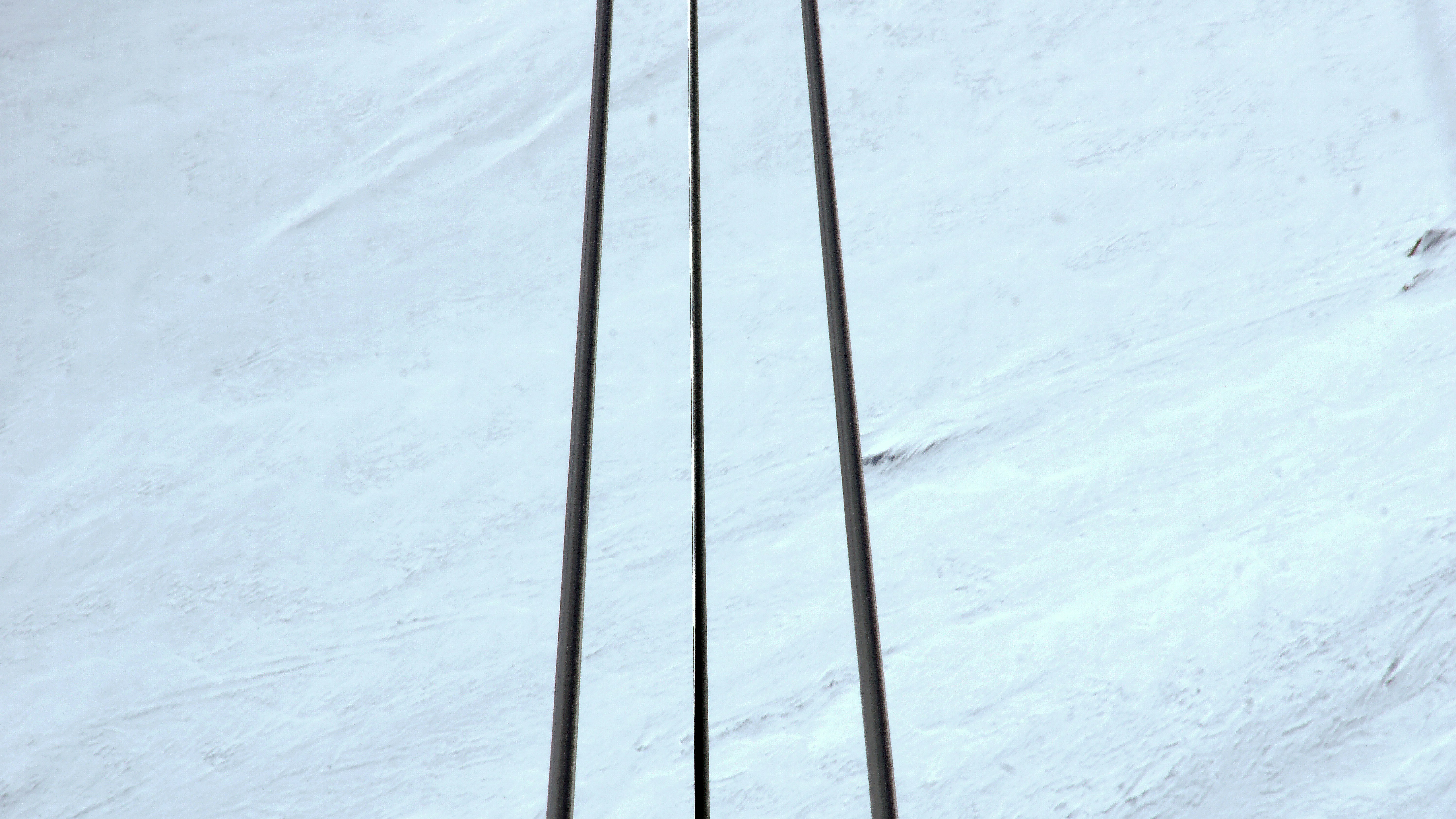 Three parallel ski tracks in fresh snow