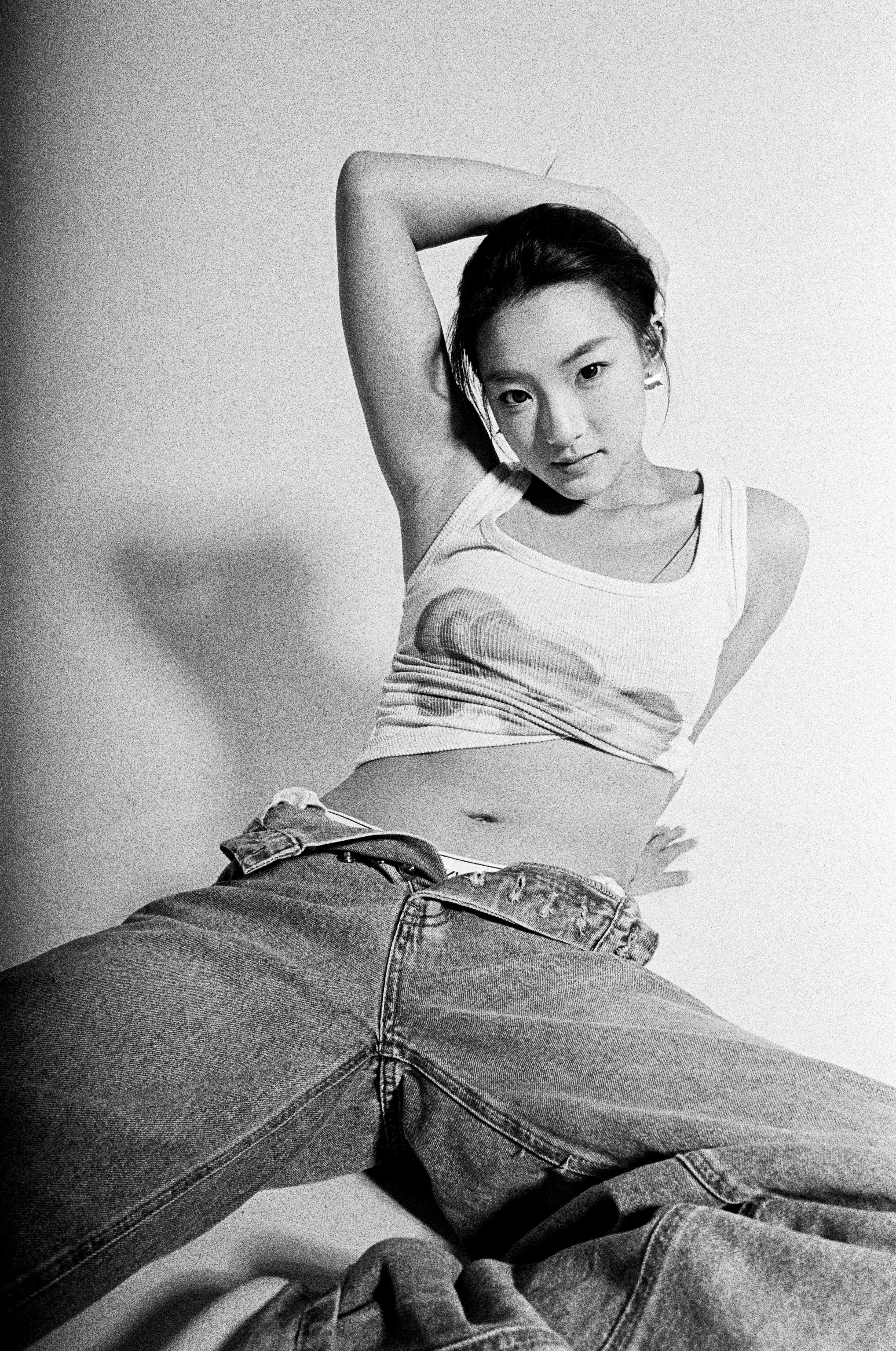 Nikon F4，Nikkor AF1.4D，Kodak T-max 4oo | Woman in tank top and jeans posing against wall
