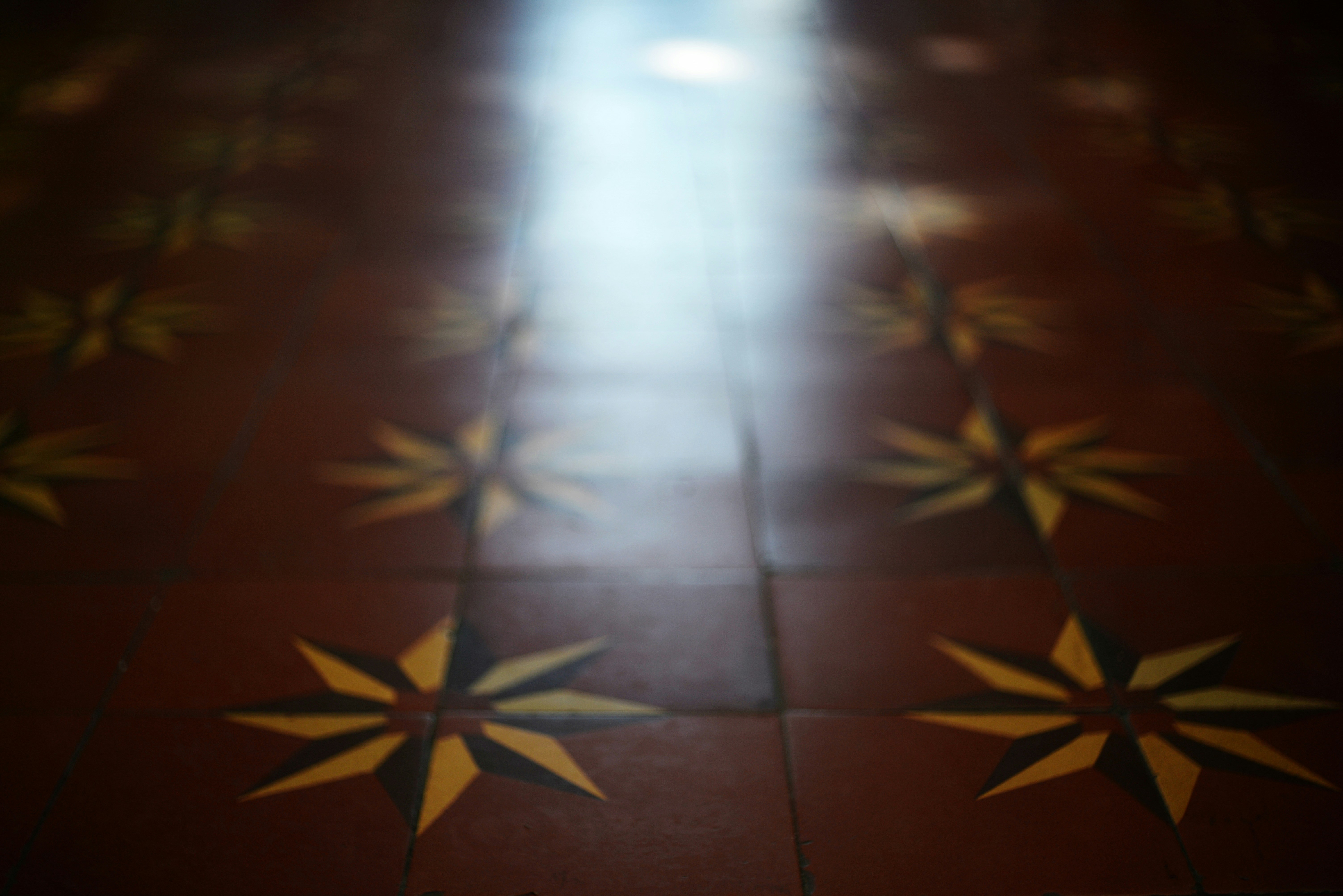 Sunlit Tile Starbursts: A Quiet Hall in Focus