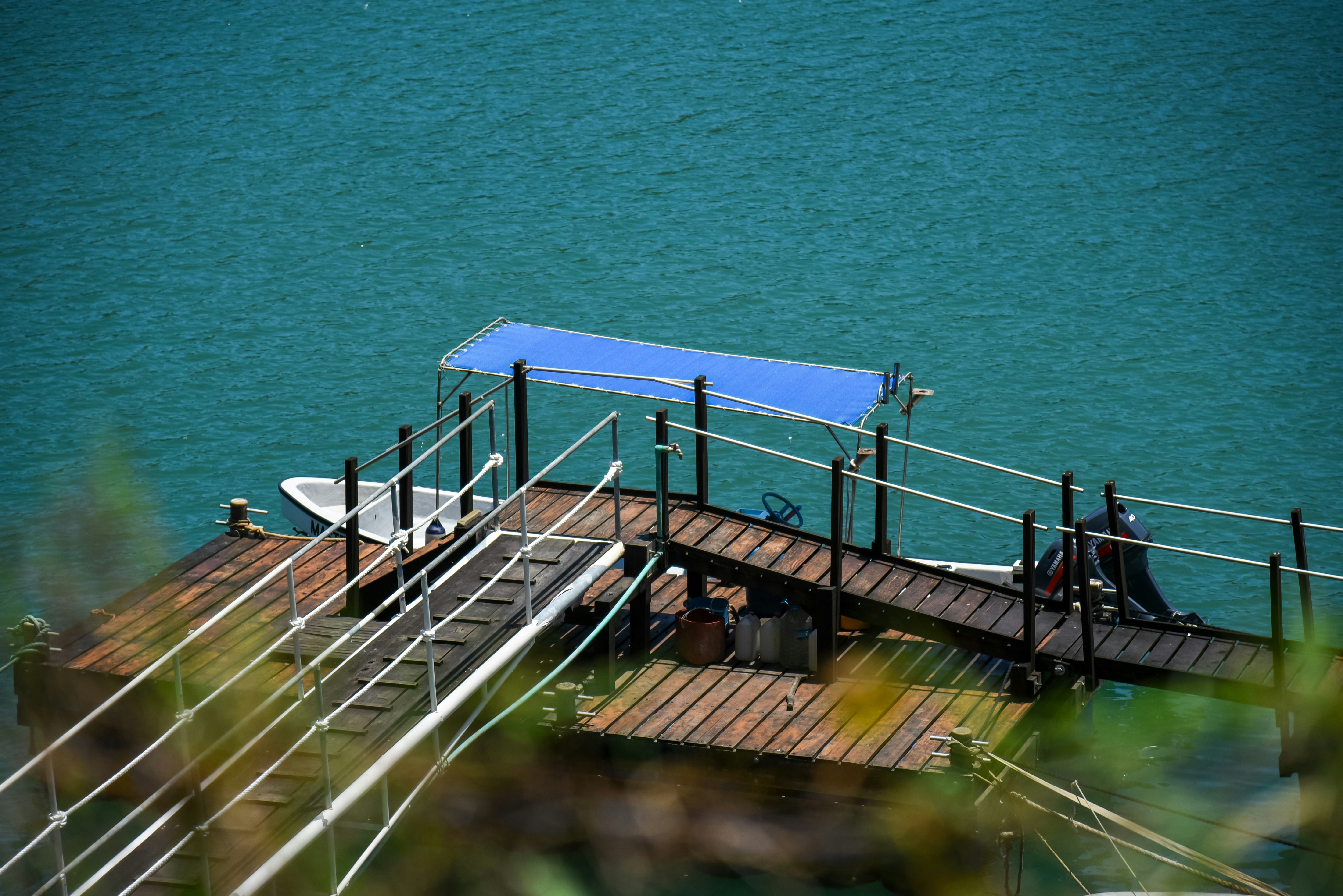 Wooden pier with blue canopy over turquoise water