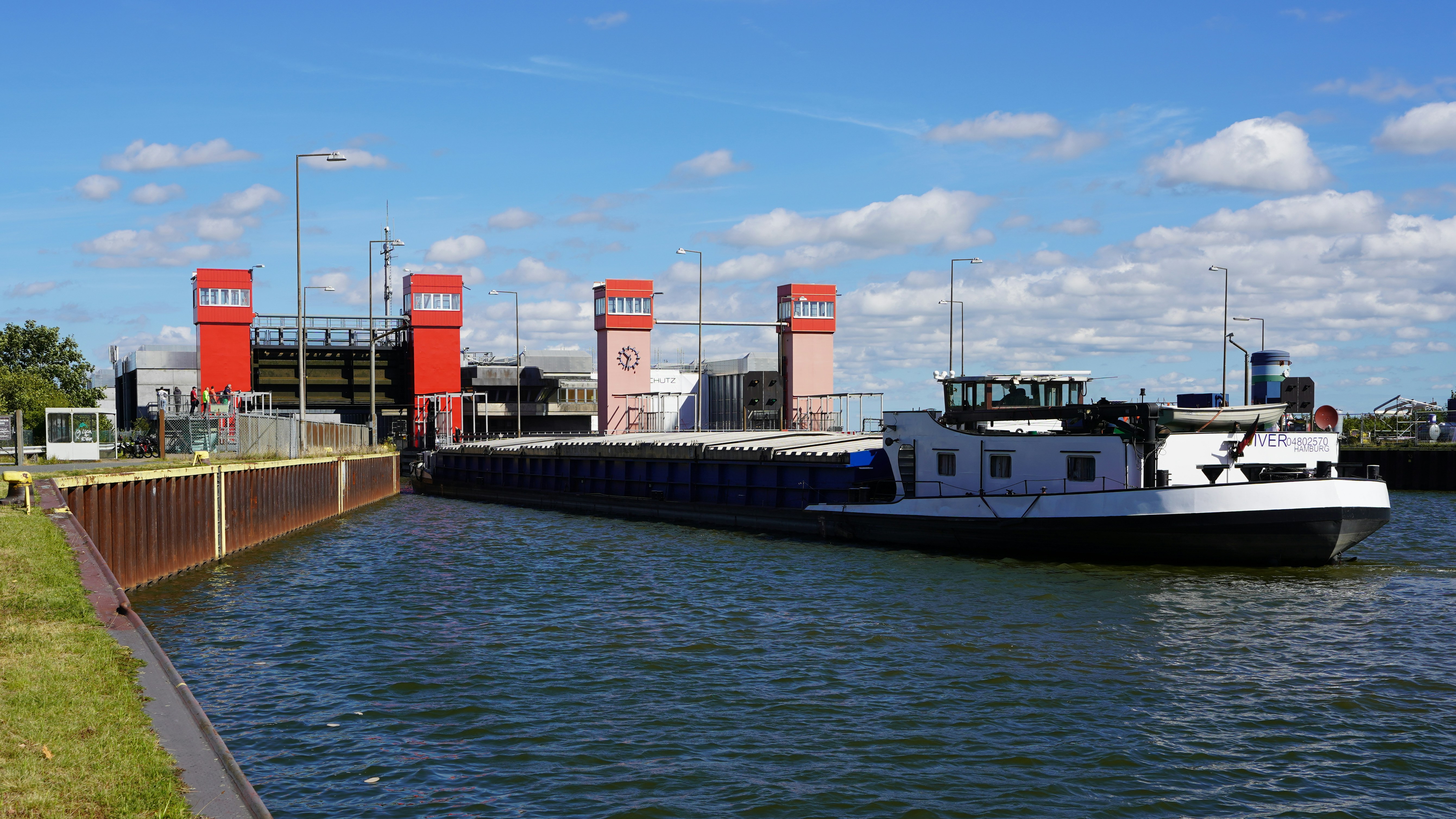 A barge passes through a lock with red towers. photo – Free Museum ...