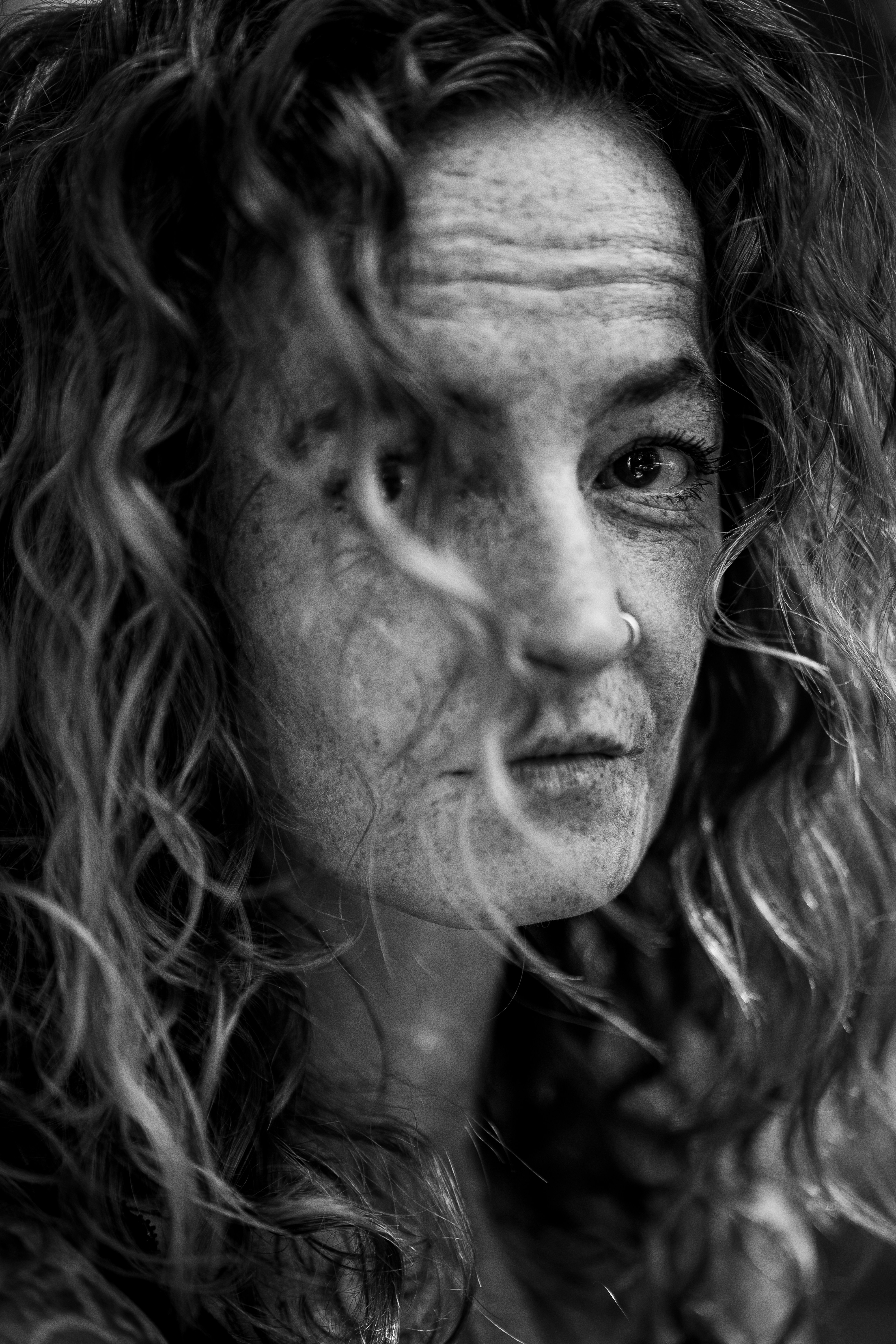 Freckled Gaze: Portrait in Wind-Driven Curls