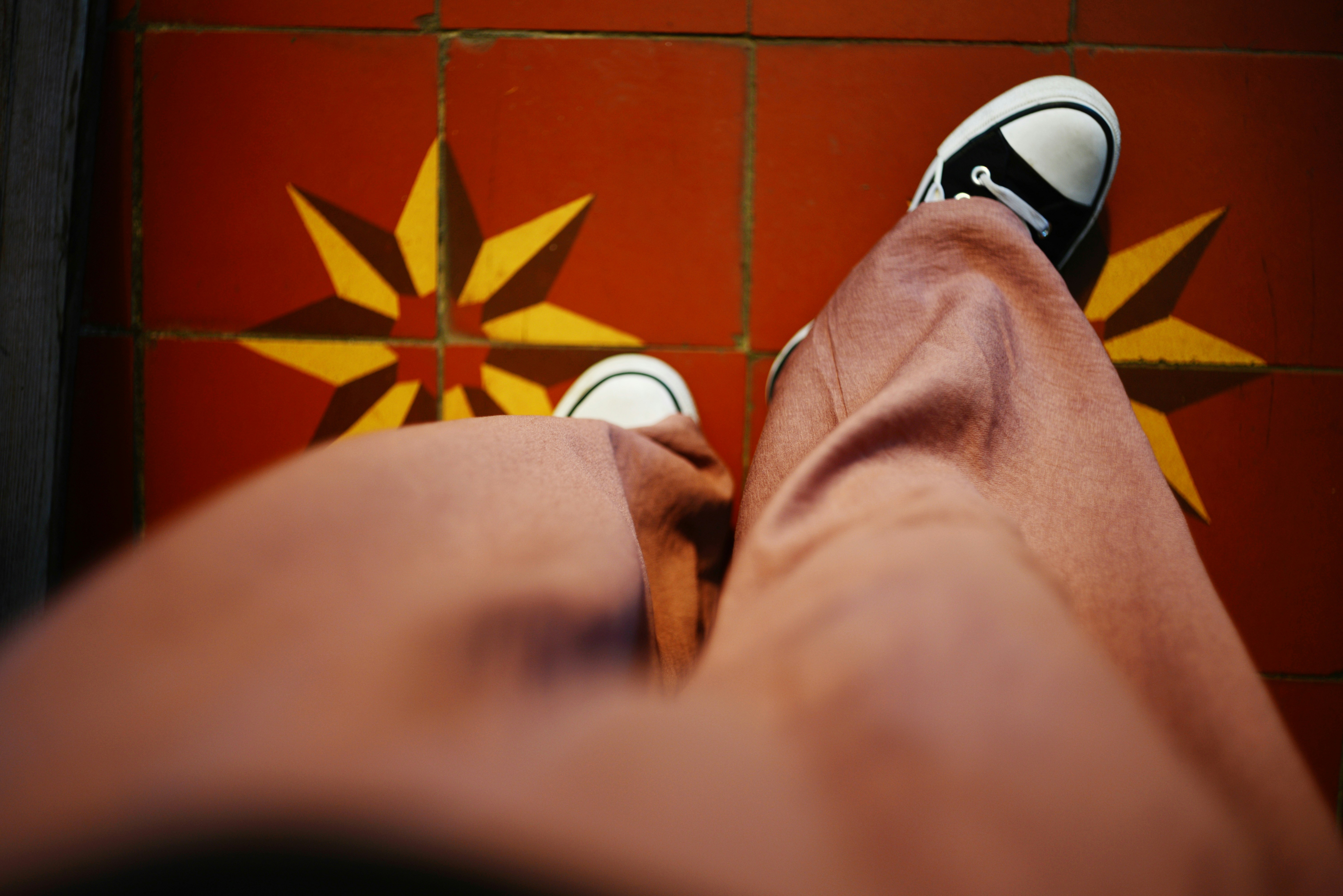 Footwear resting on a vibrant tiled floor featuring a star pattern, showcasing a blend of colors and textures.