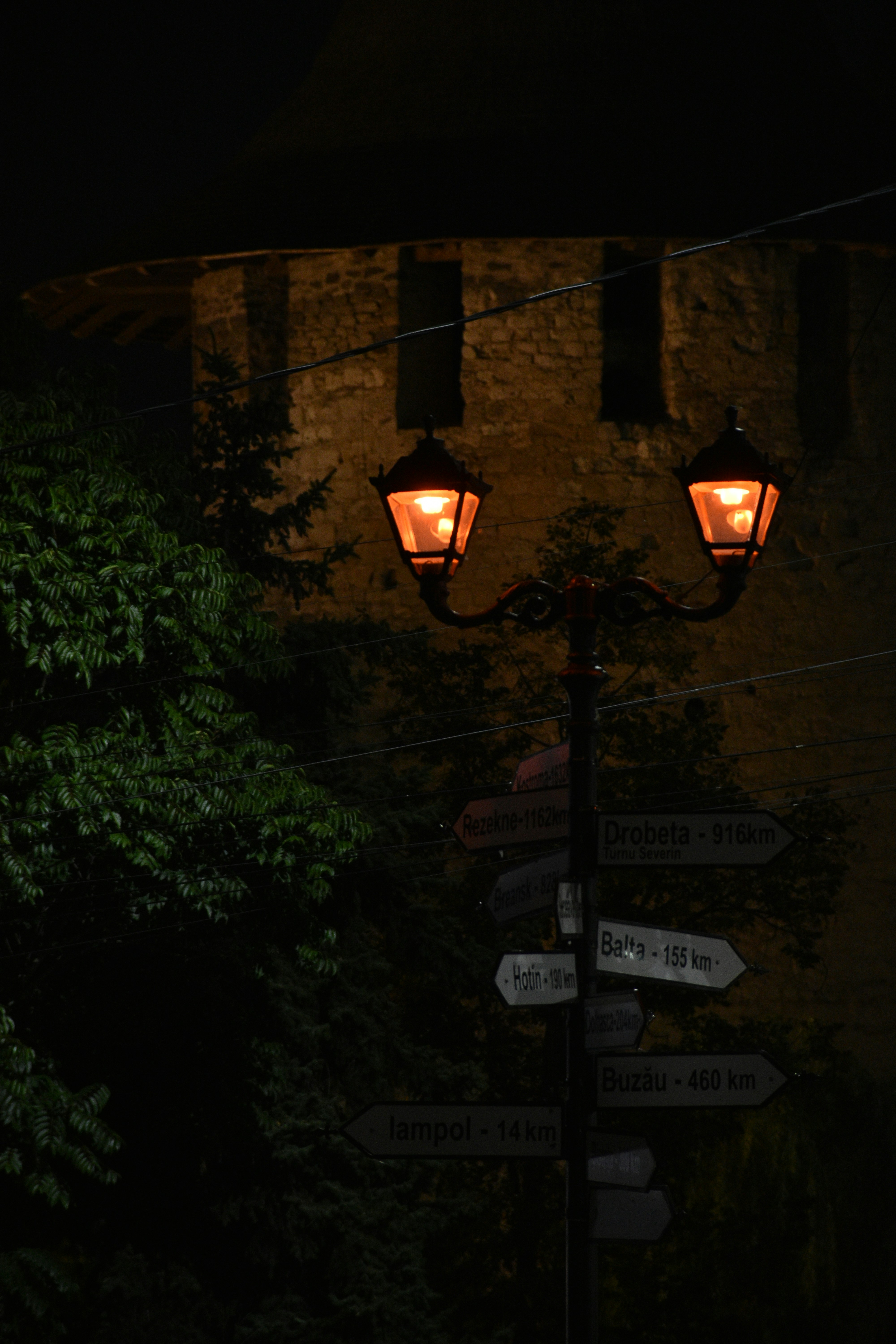 Twin Lanterns Over a Stone-Walled Night Signpost