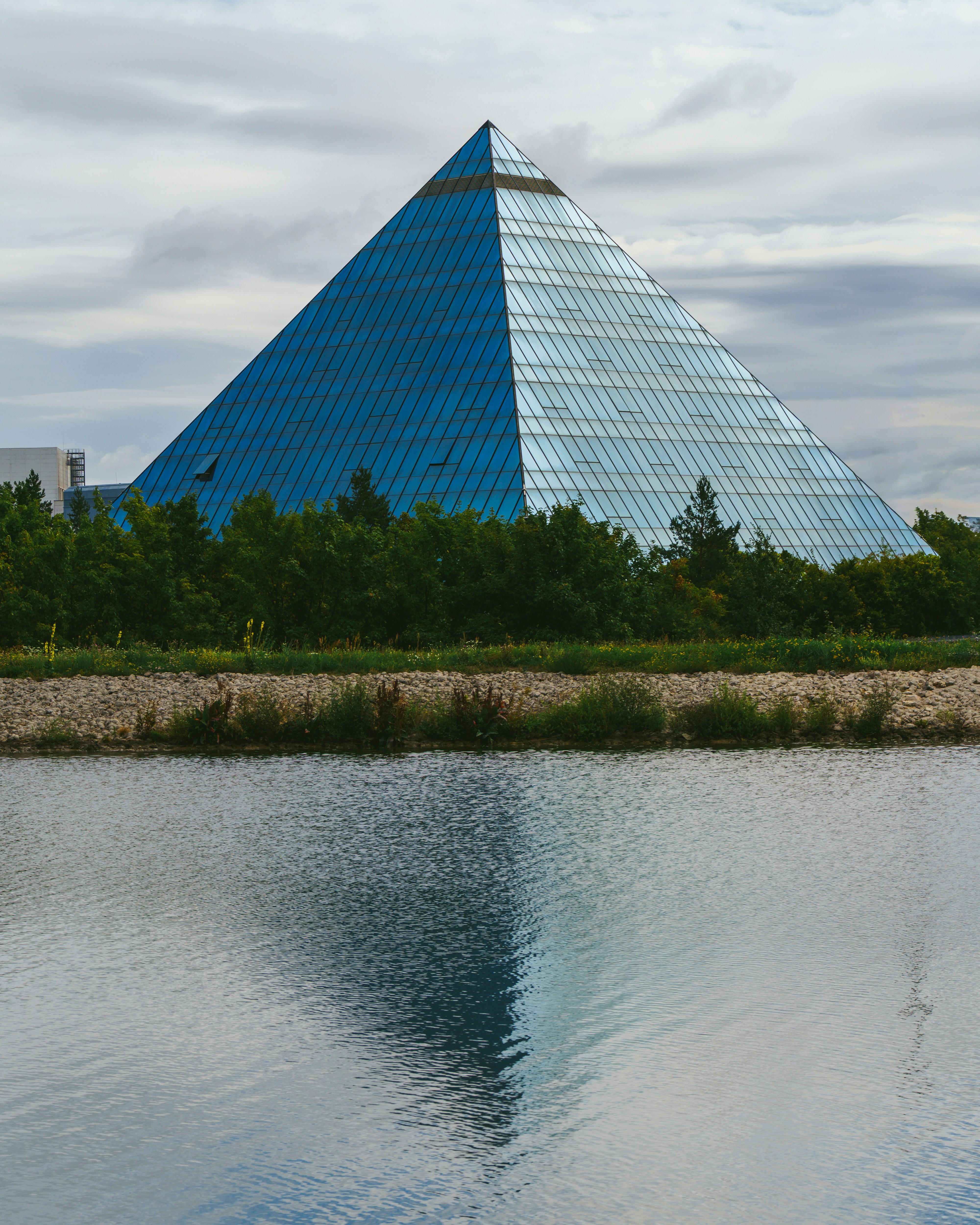 Glass pyramid building reflected in water