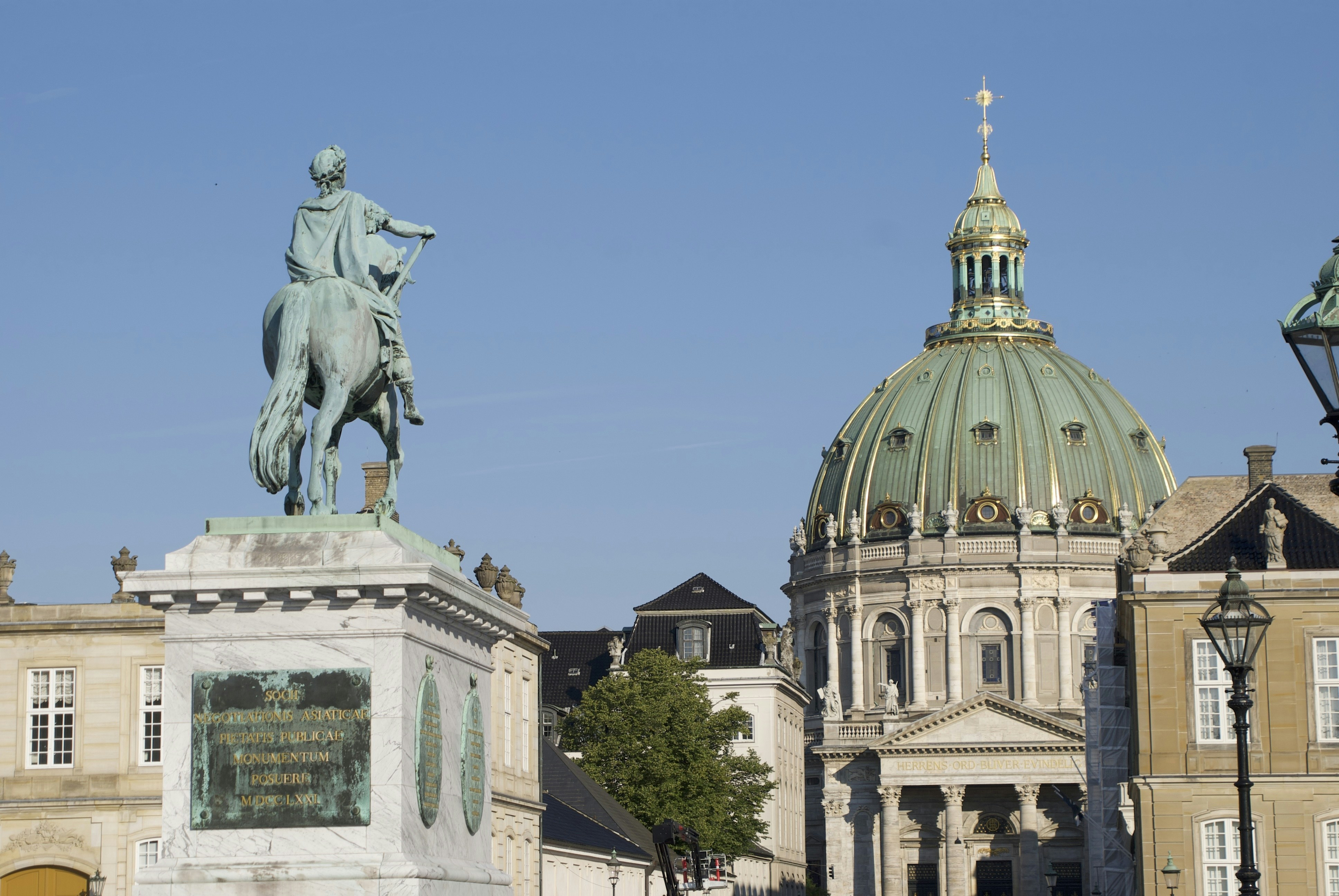 Equestrian statue in front of a domed building.
