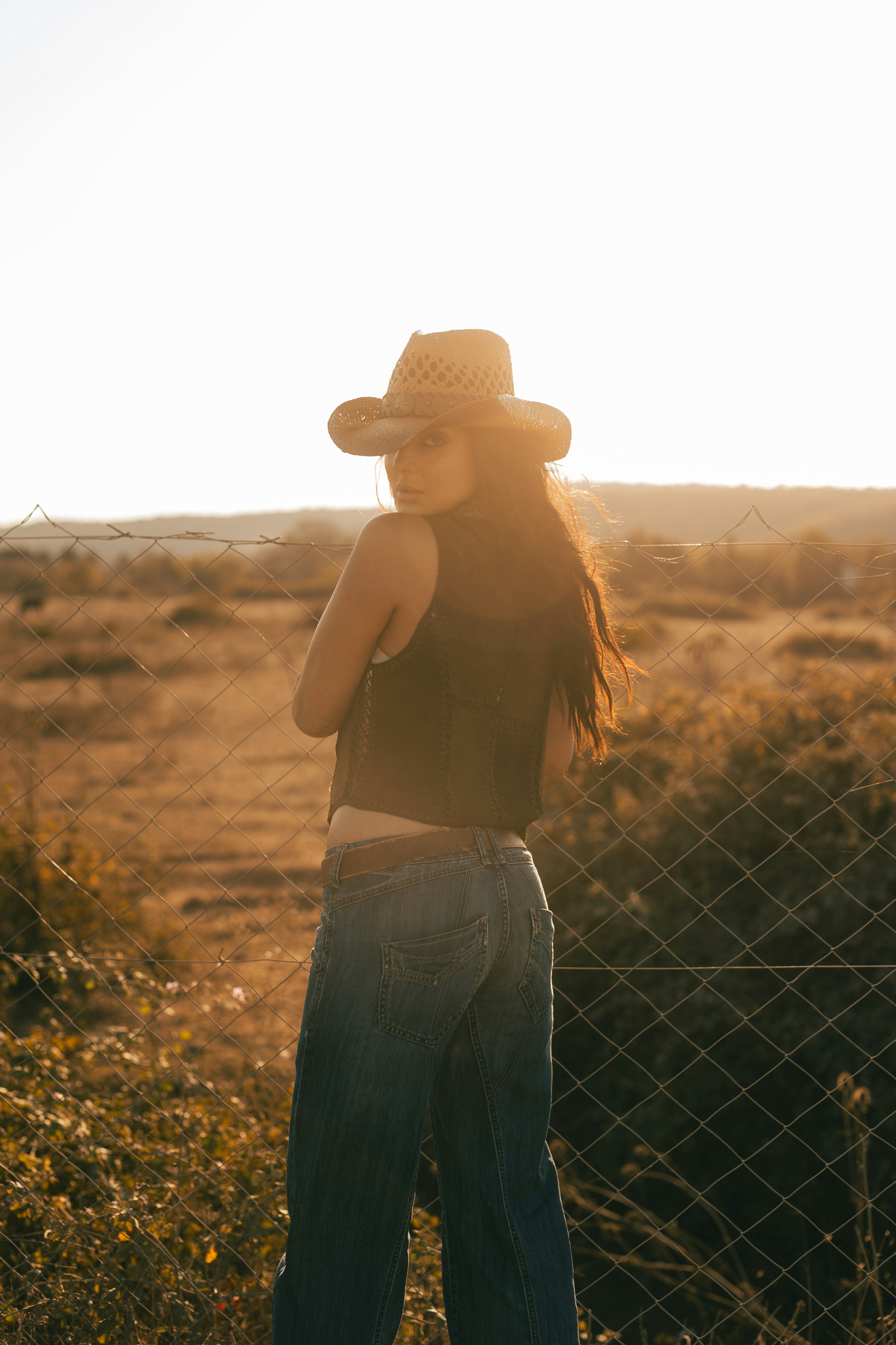Woman in cowboy hat looking over shoulder at sunset photo – Free Image ...