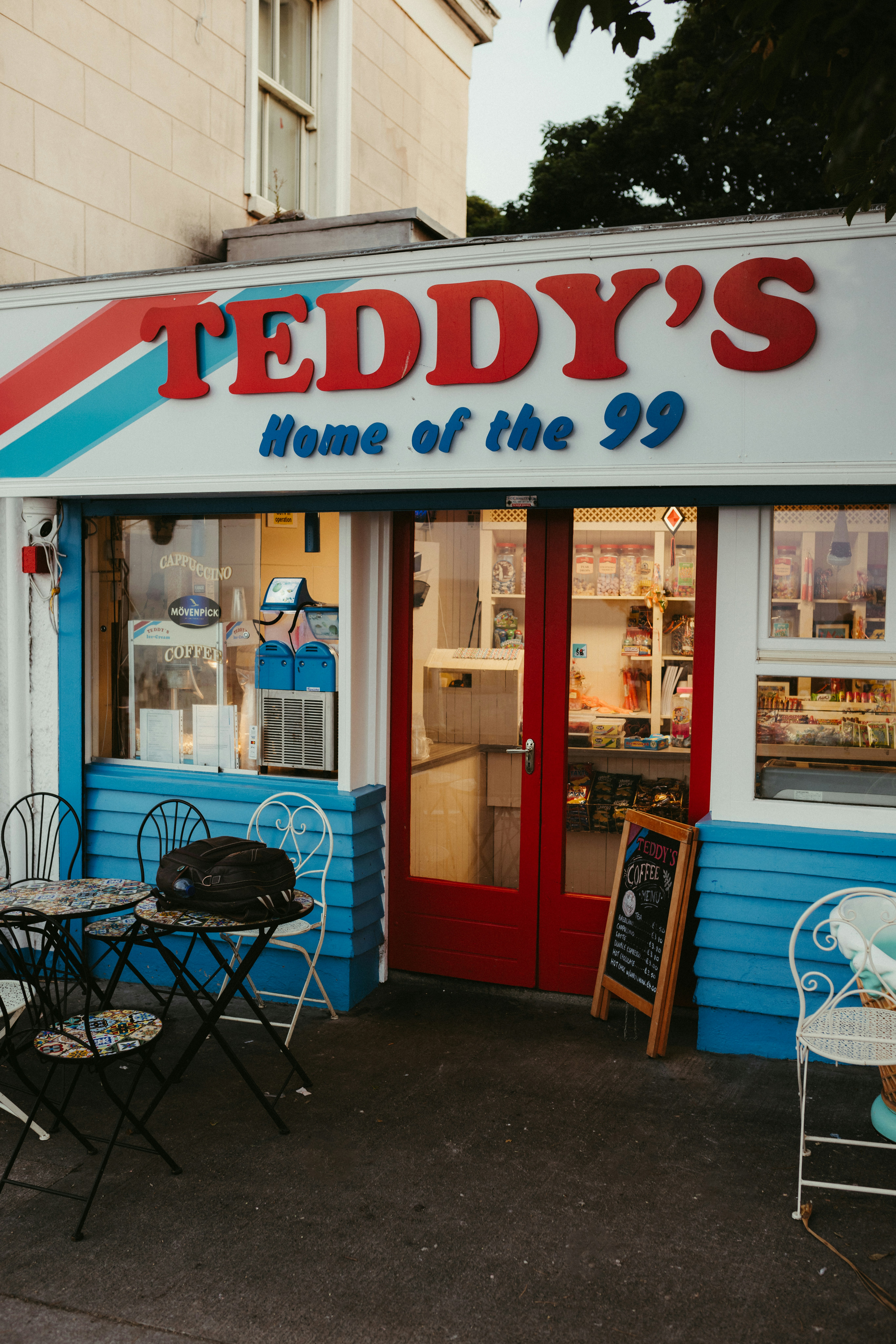 Teddy’s Café Front: Bright Signage and Red Door Inviting Customers