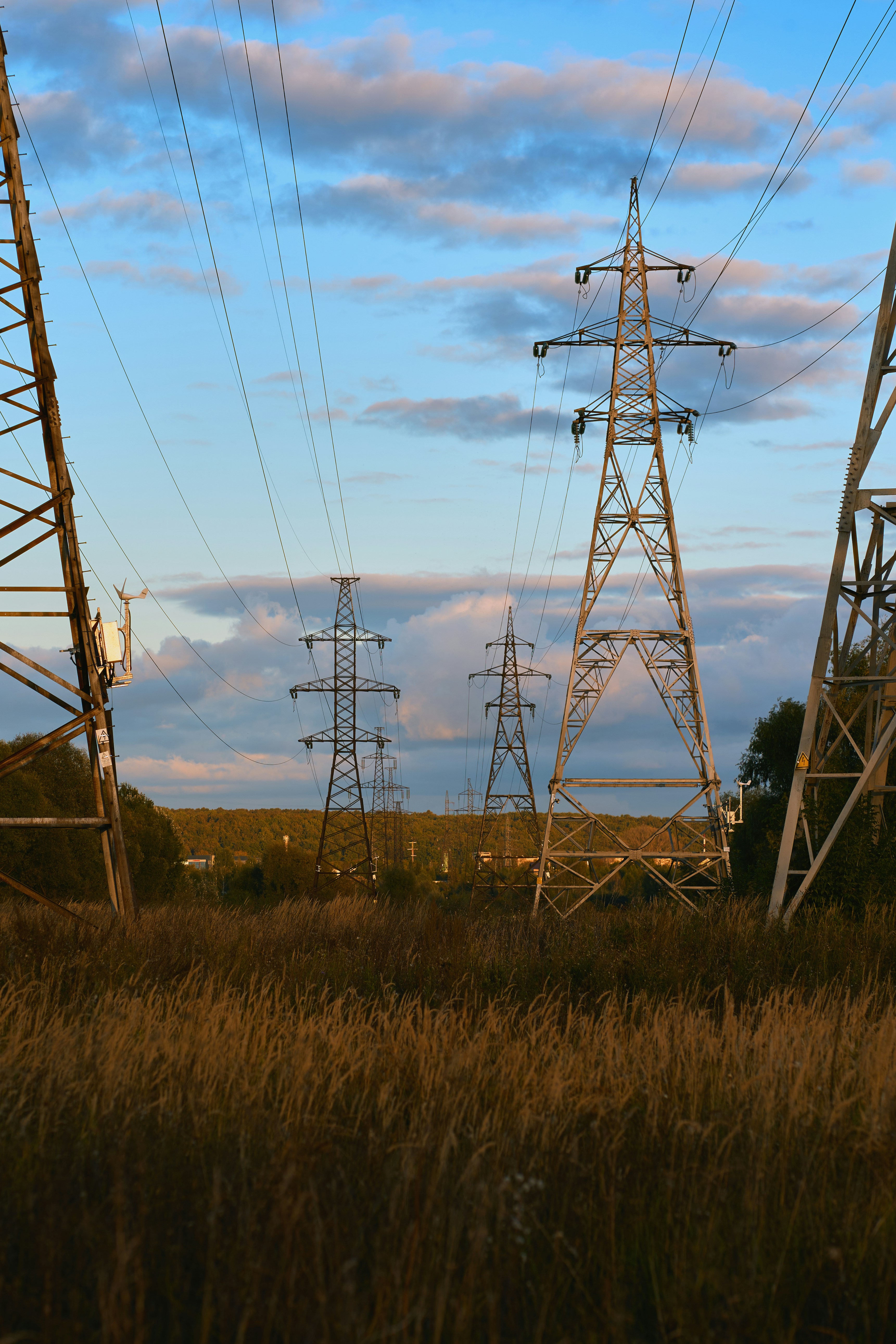 Power lines and towers in a field at sunset.