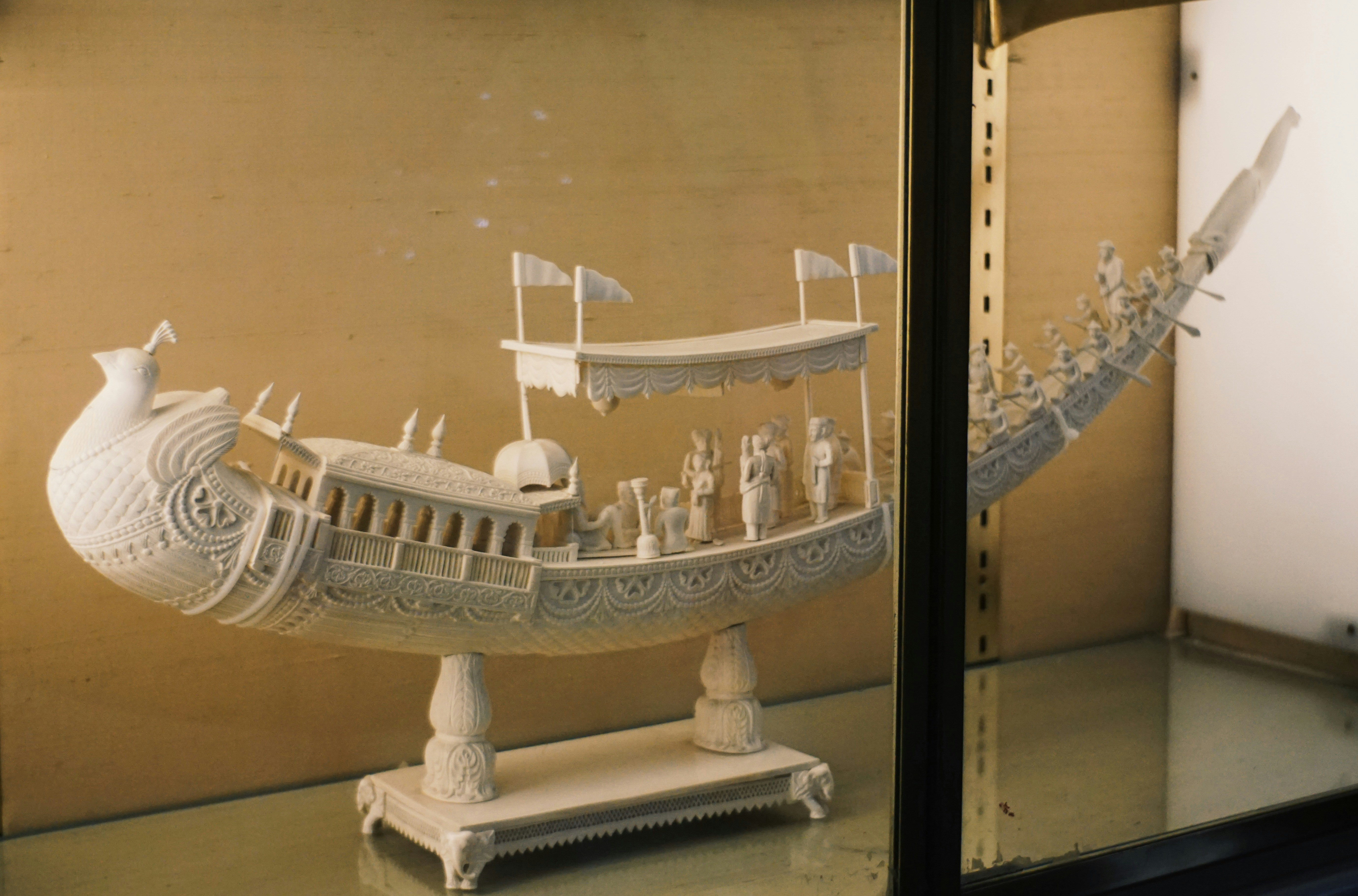 Intricate ivory carving of a ceremonial boat with figures.