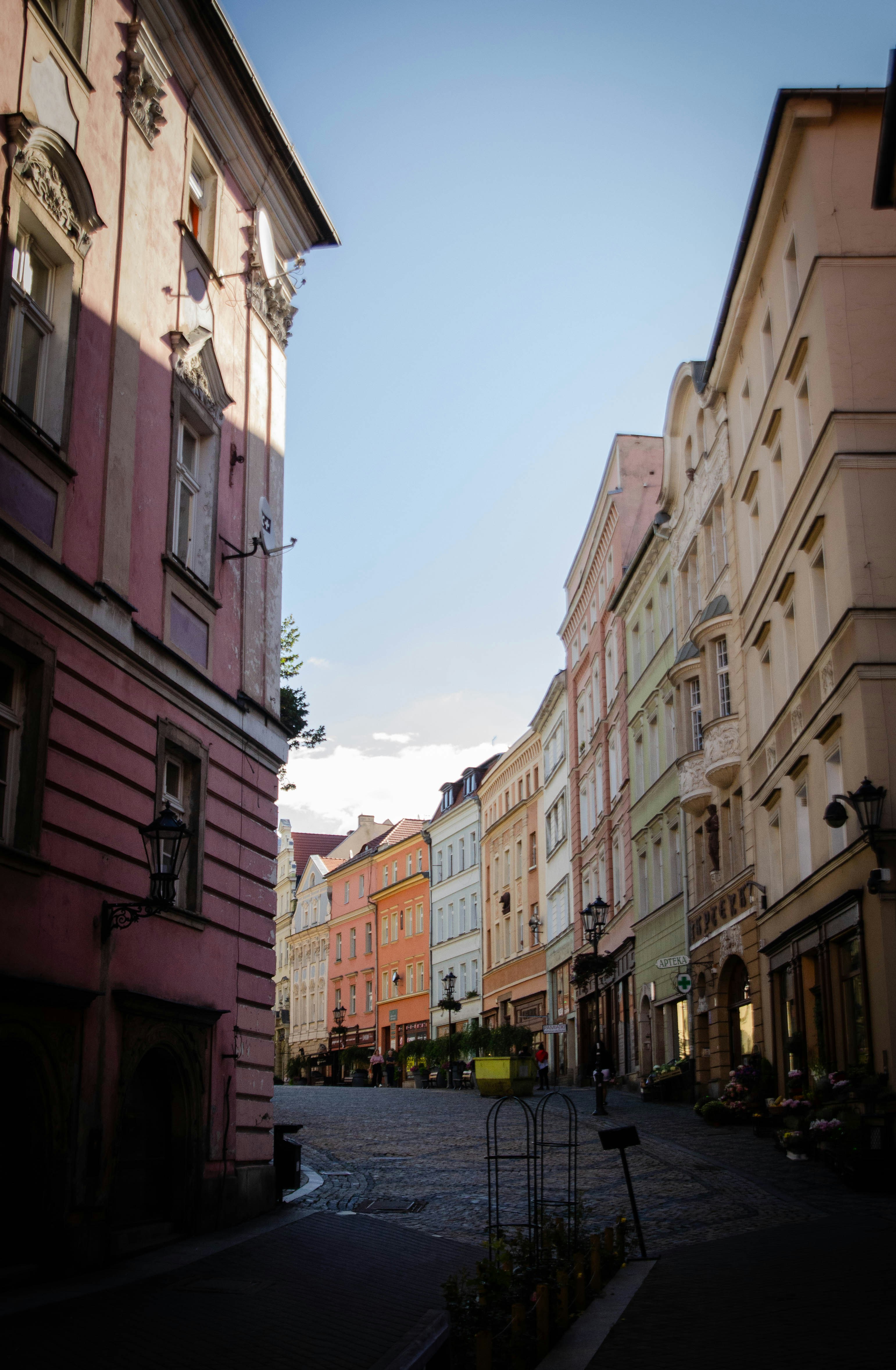 Colorful buildings line a cobblestone street in europe.