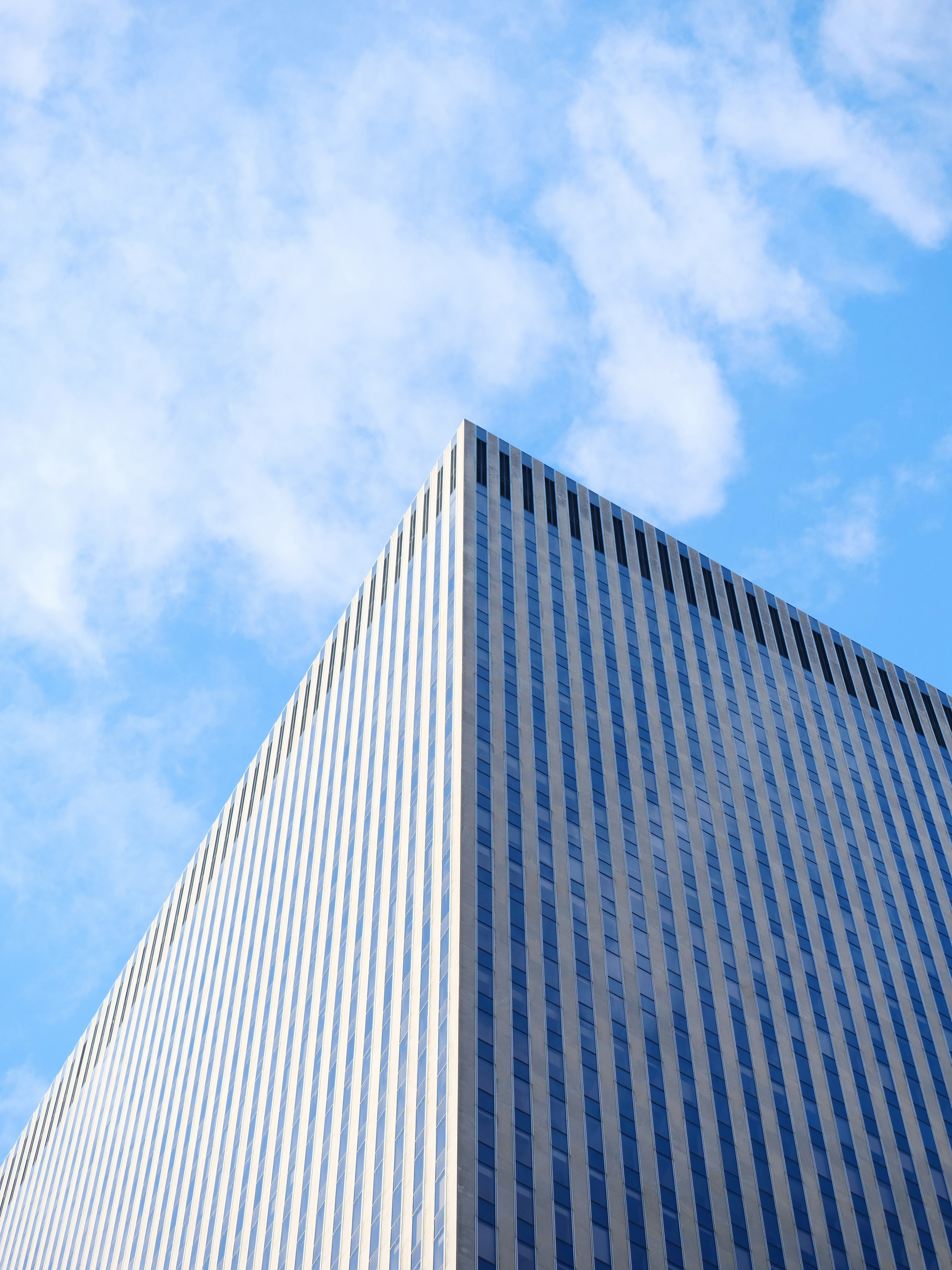Modern skyscraper against a bright blue sky.