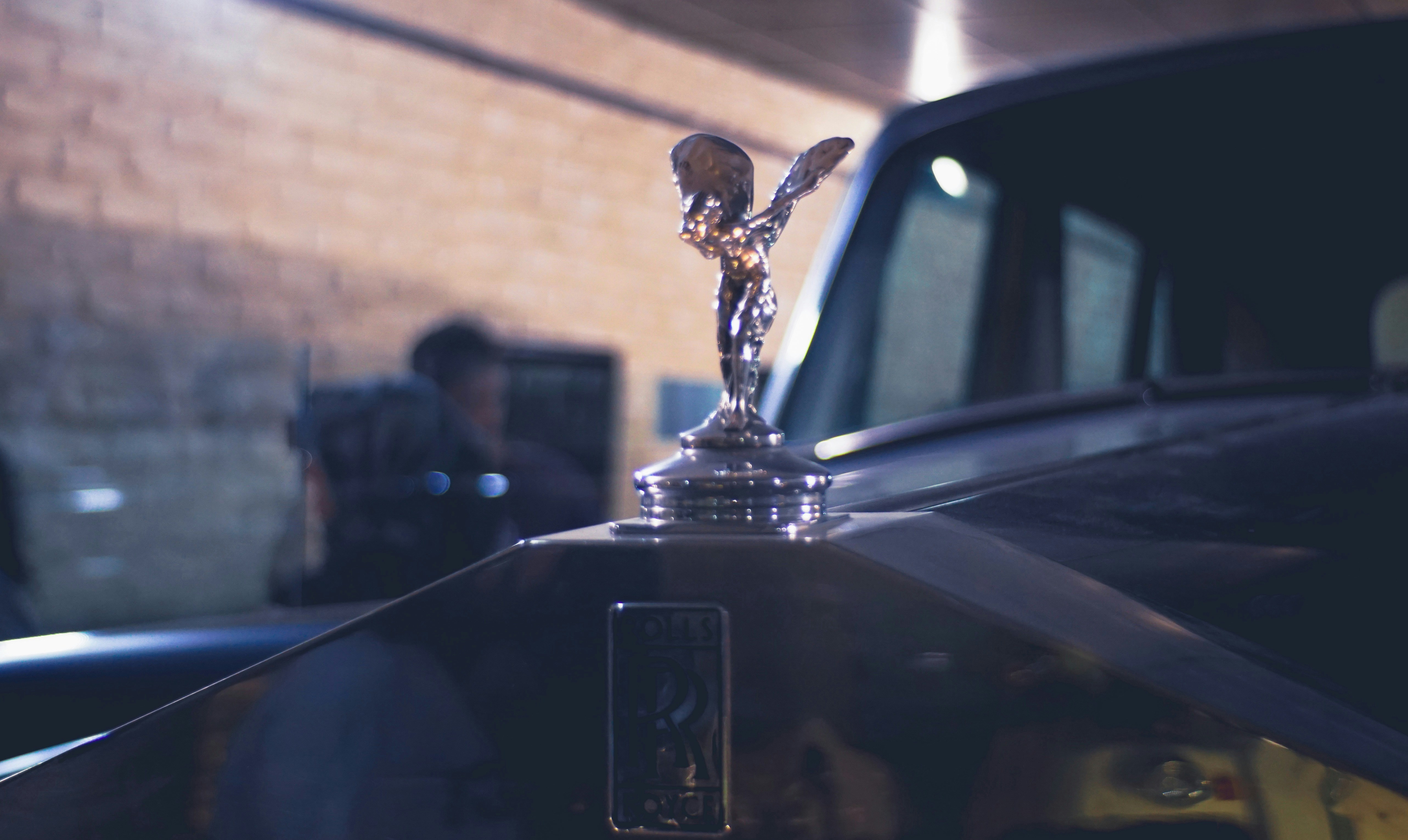 Rolls-royce hood ornament on a dark car
