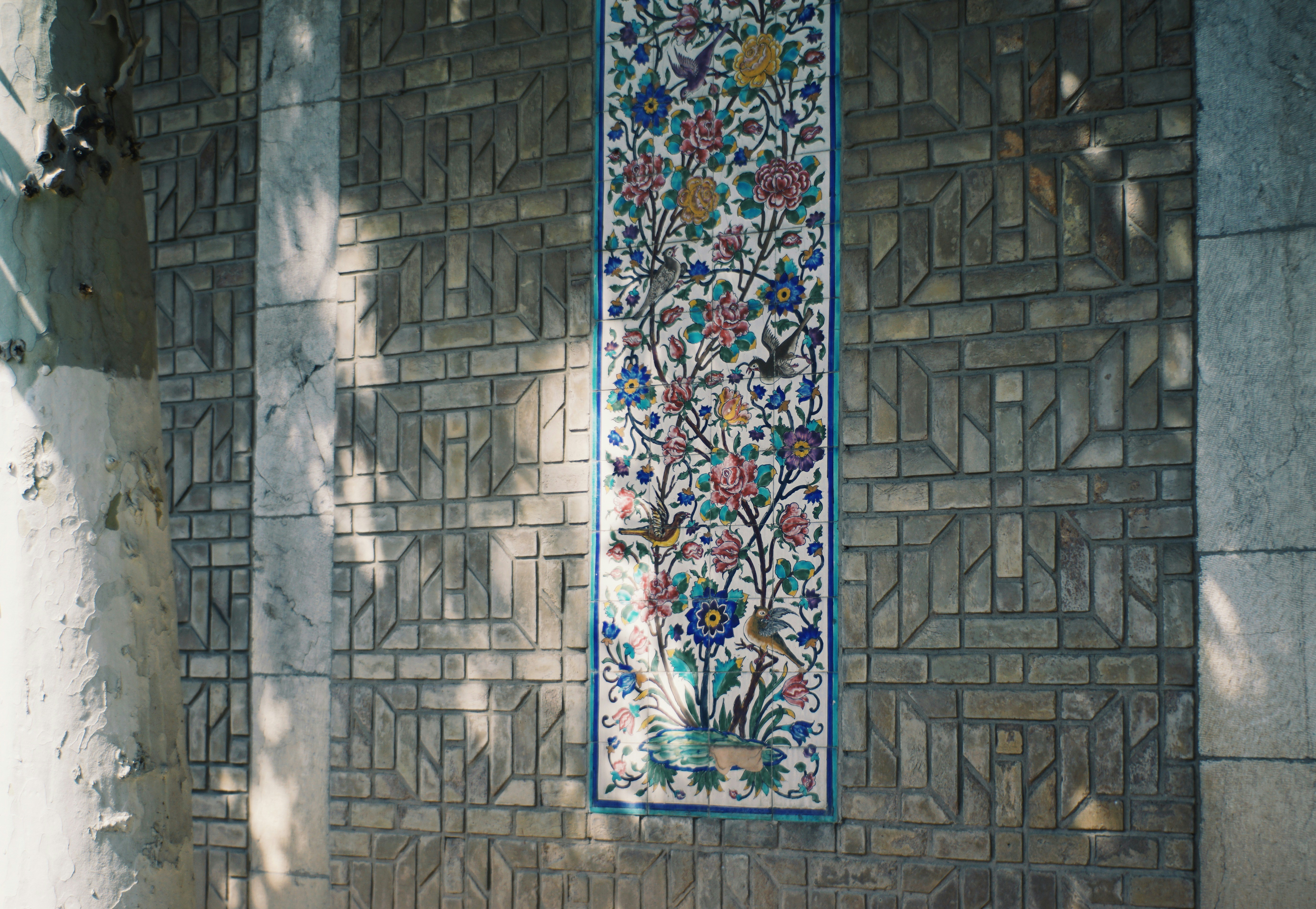 Ornate floral artwork adorns a textured wall.